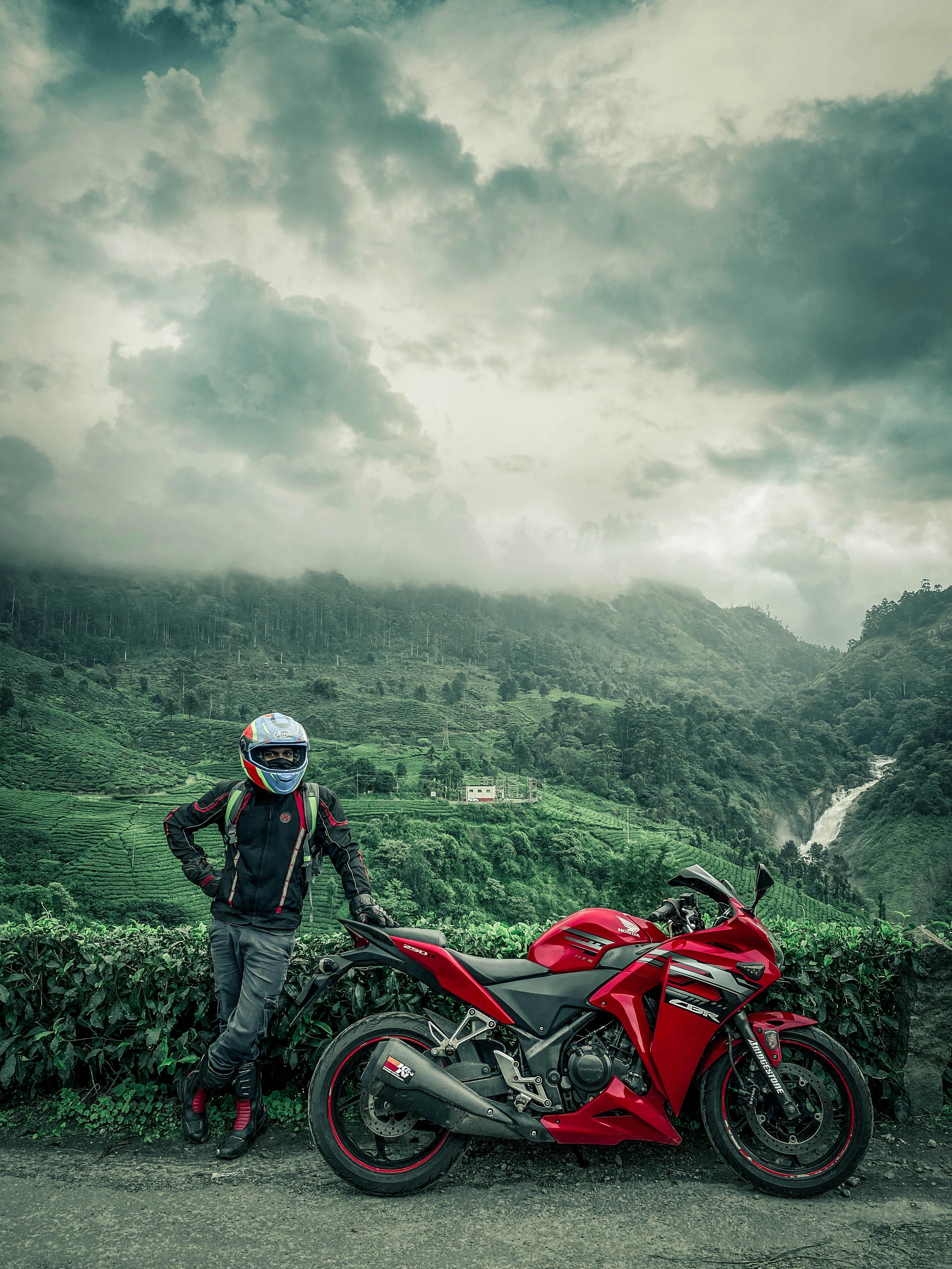 A Man Standing Beside the Red Motorcycle · Free Stock Photo