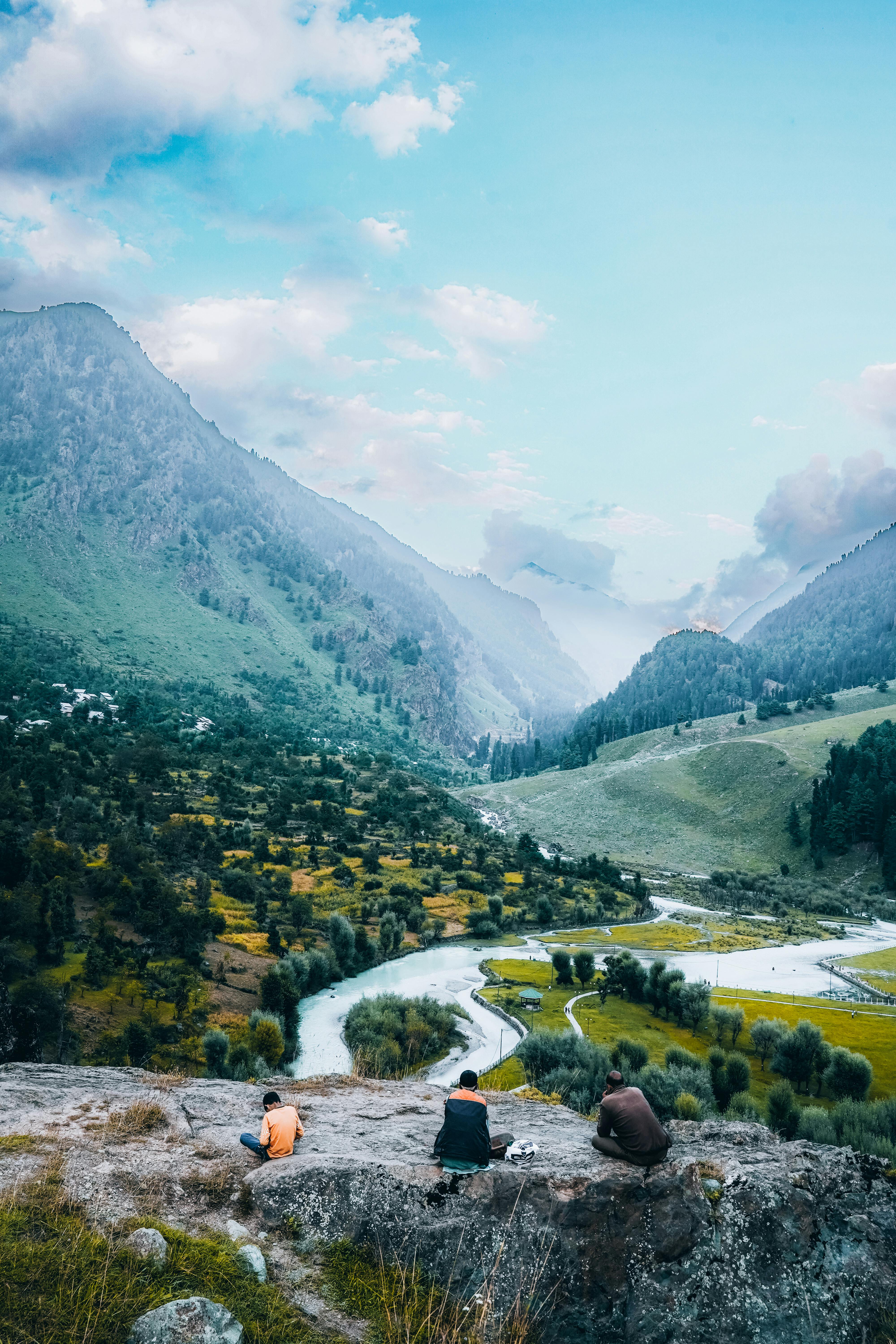 People Sitting near River in Valley · Free Stock Photo