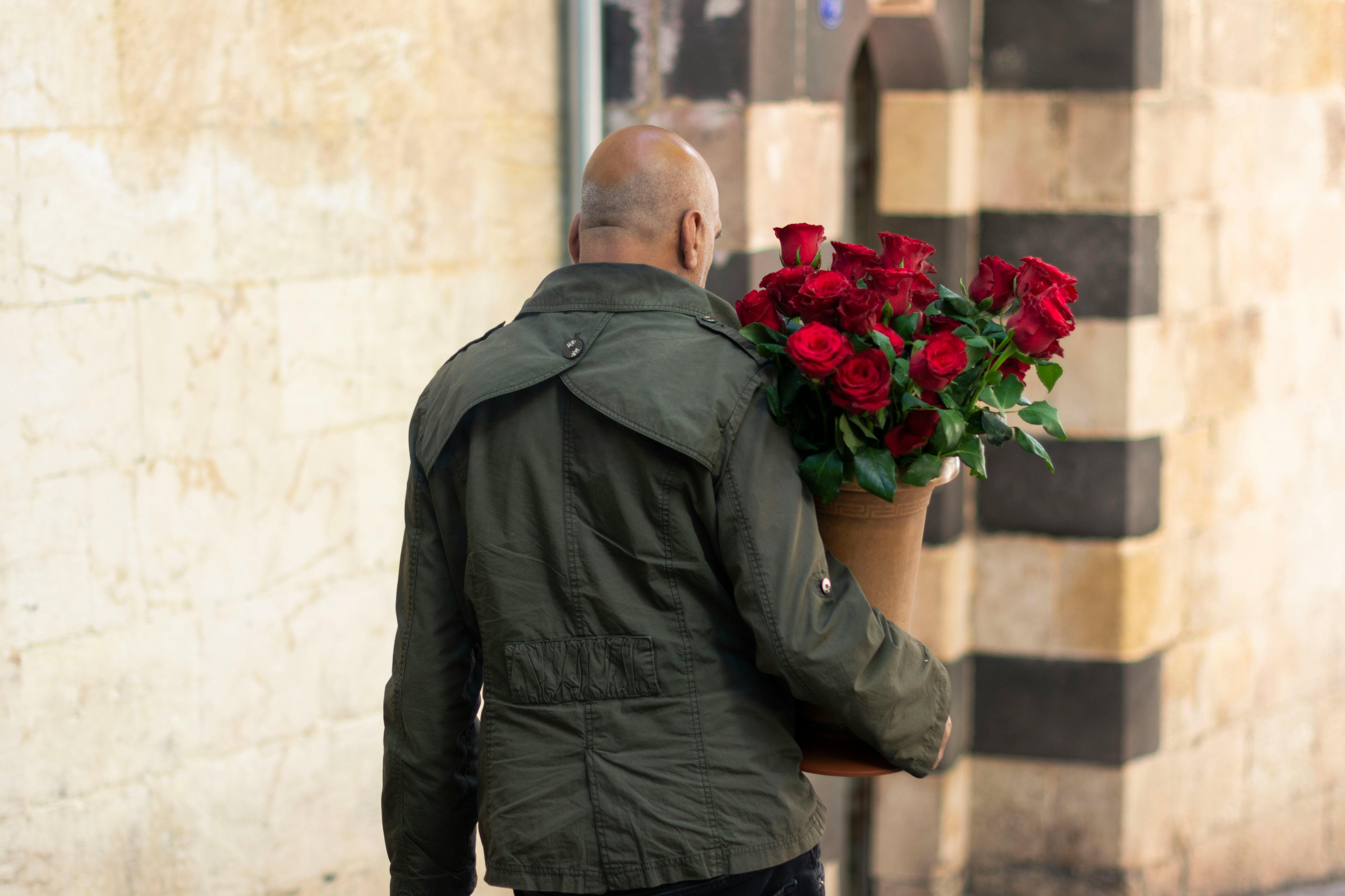 Backview of Man carrying Red Roses · Free Stock Photo