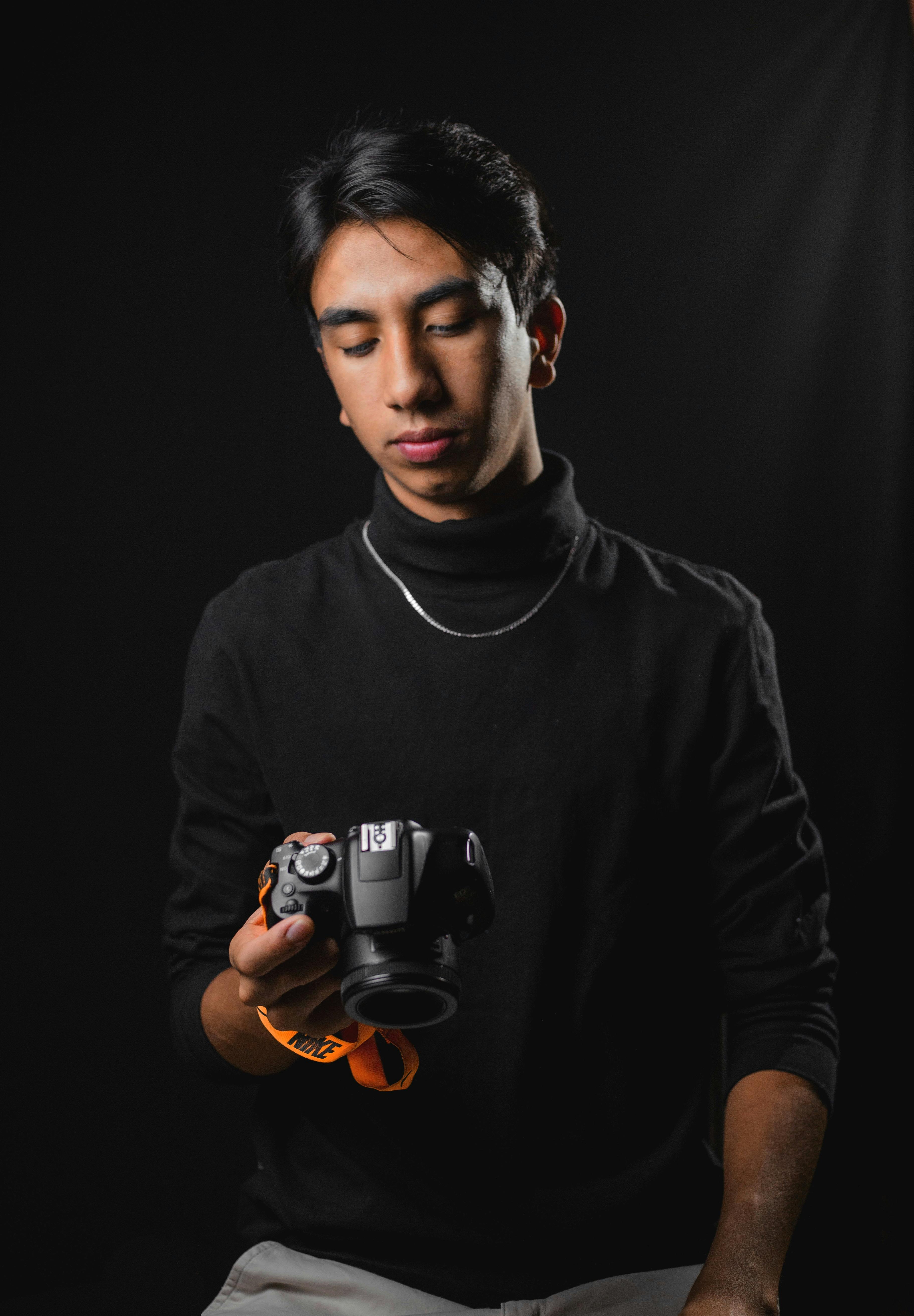 Male Teenager Holding Vintage Camera and Turning Camera Lens · Free ...