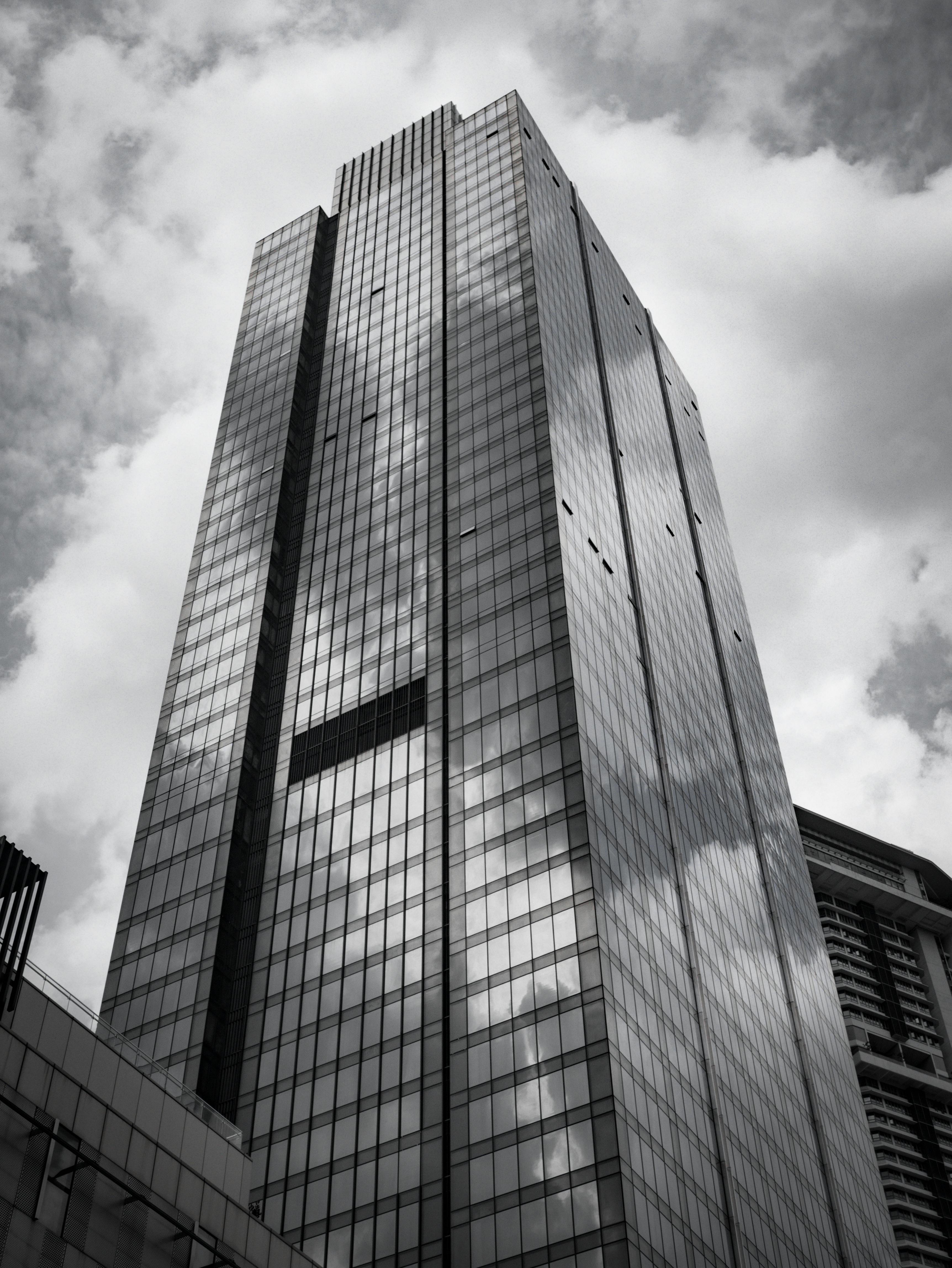 Grayscale Photo of Concrete Building under Cloudy Sky · Free Stock Photo