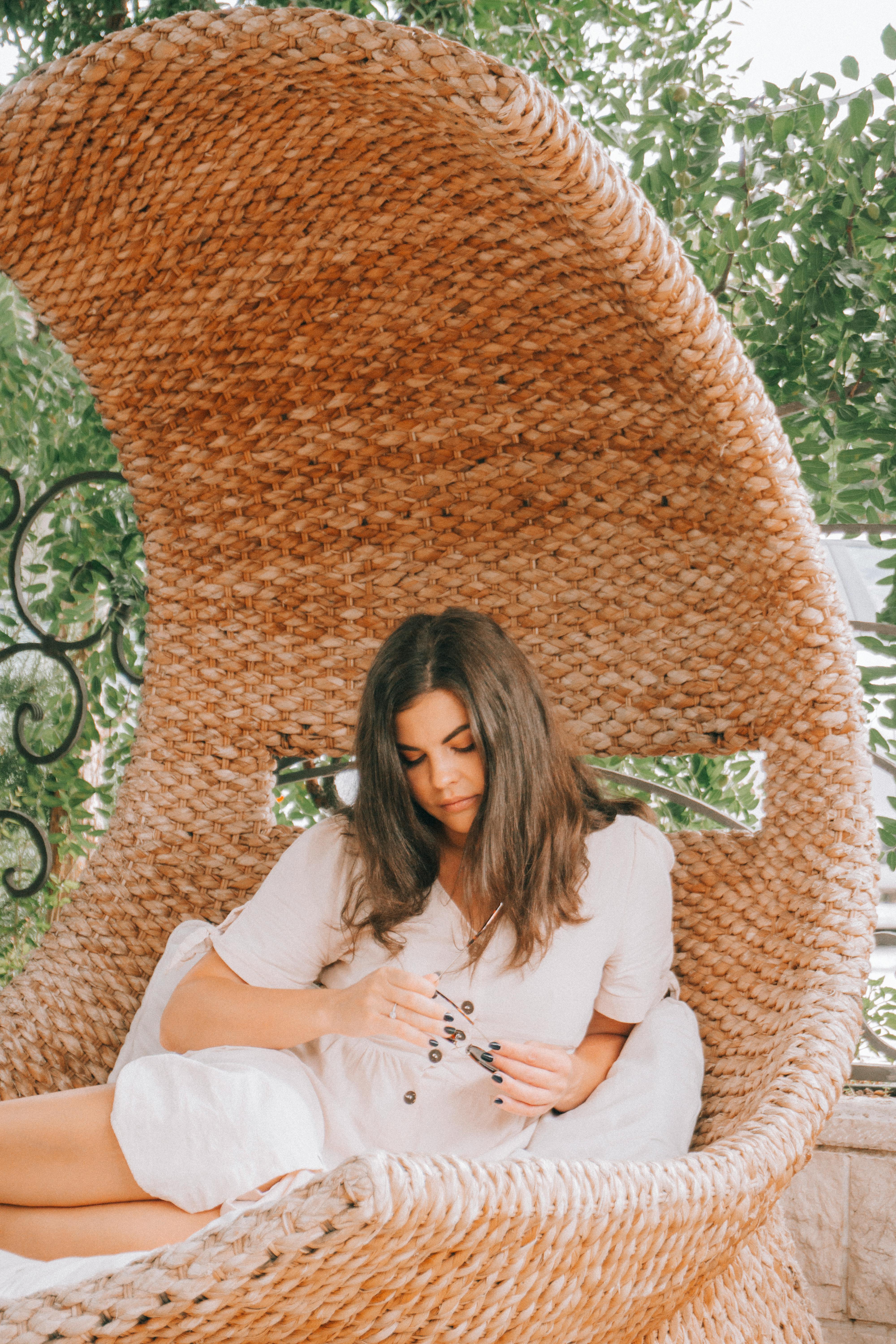 Woman Lying in Large Wicker Chair · Free Stock Photo