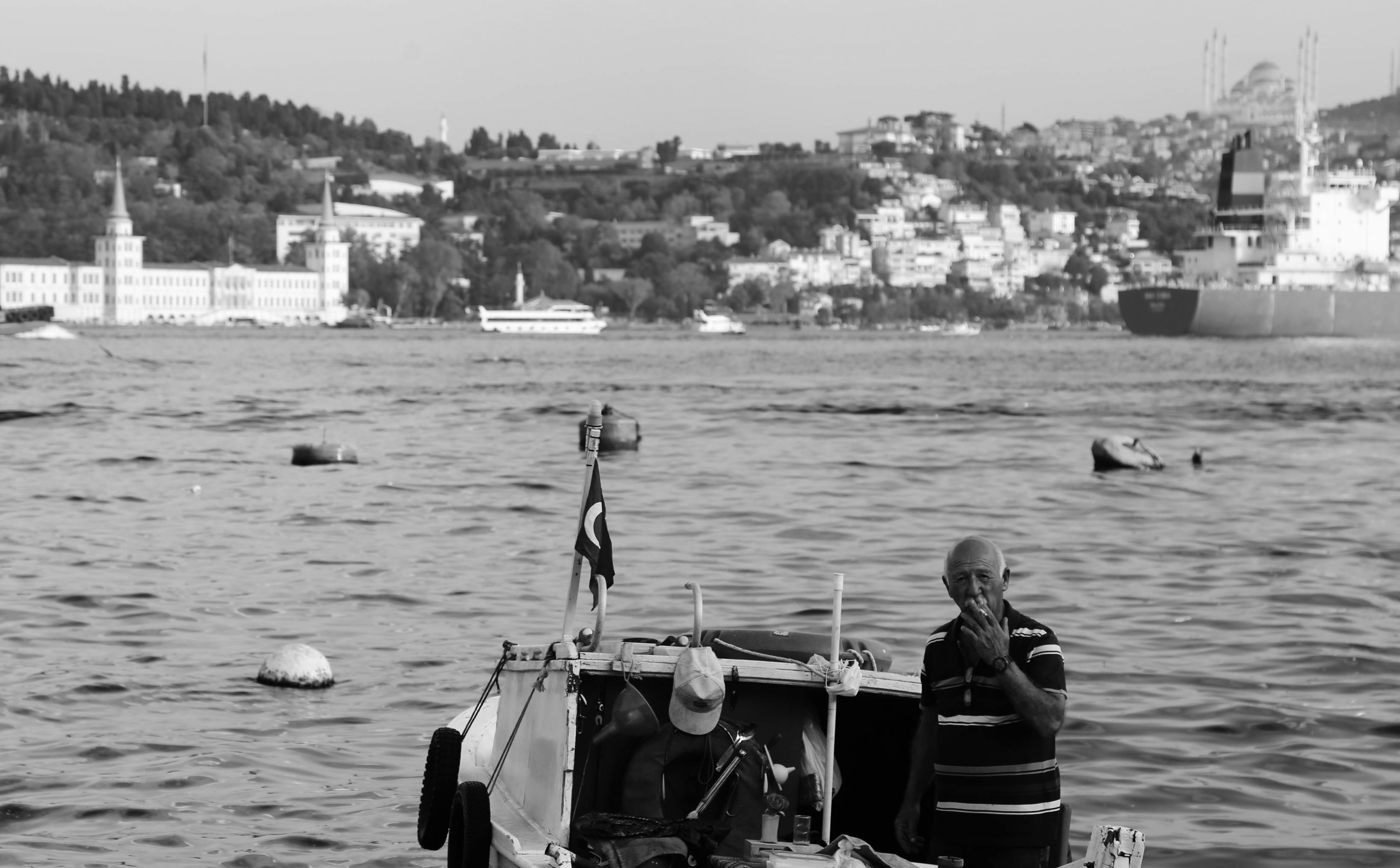 Grayscale Photo of a Man Cruising on His Motorboat · Free Stock Photo
