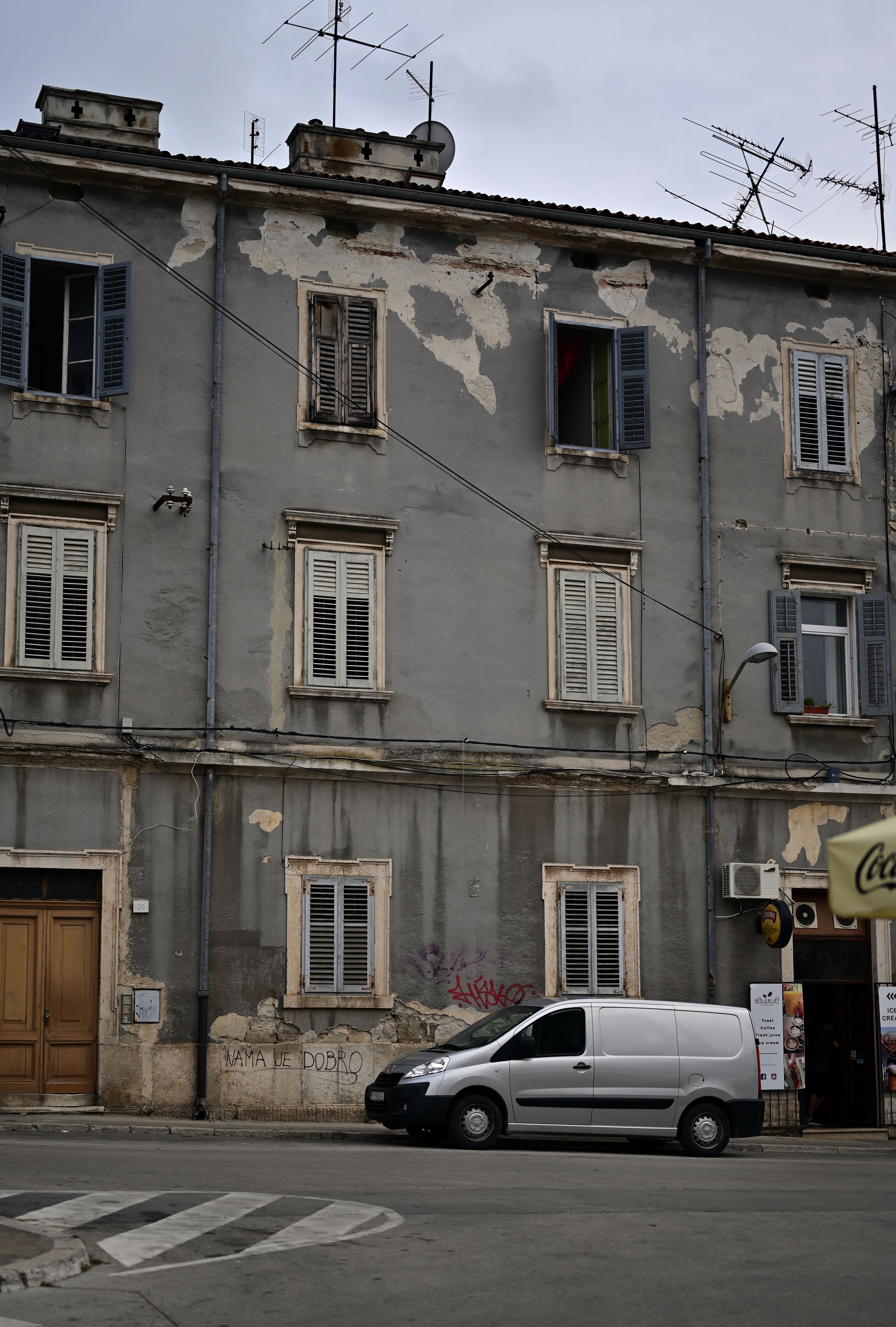 Van Parked Outside a Shabby Building · Free Stock Photo