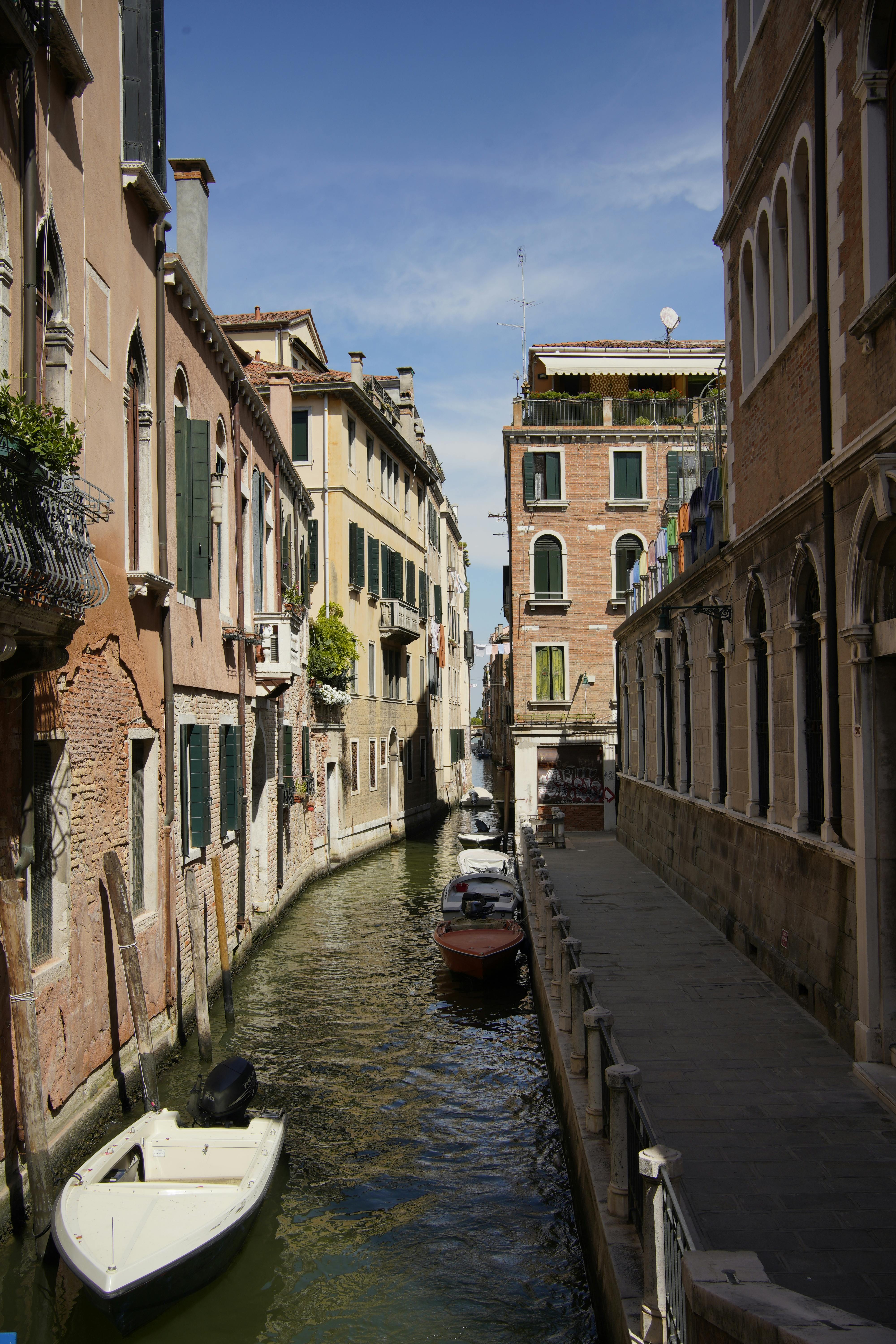 Boats Docked on a Canal Between Buildings · Free Stock Photo