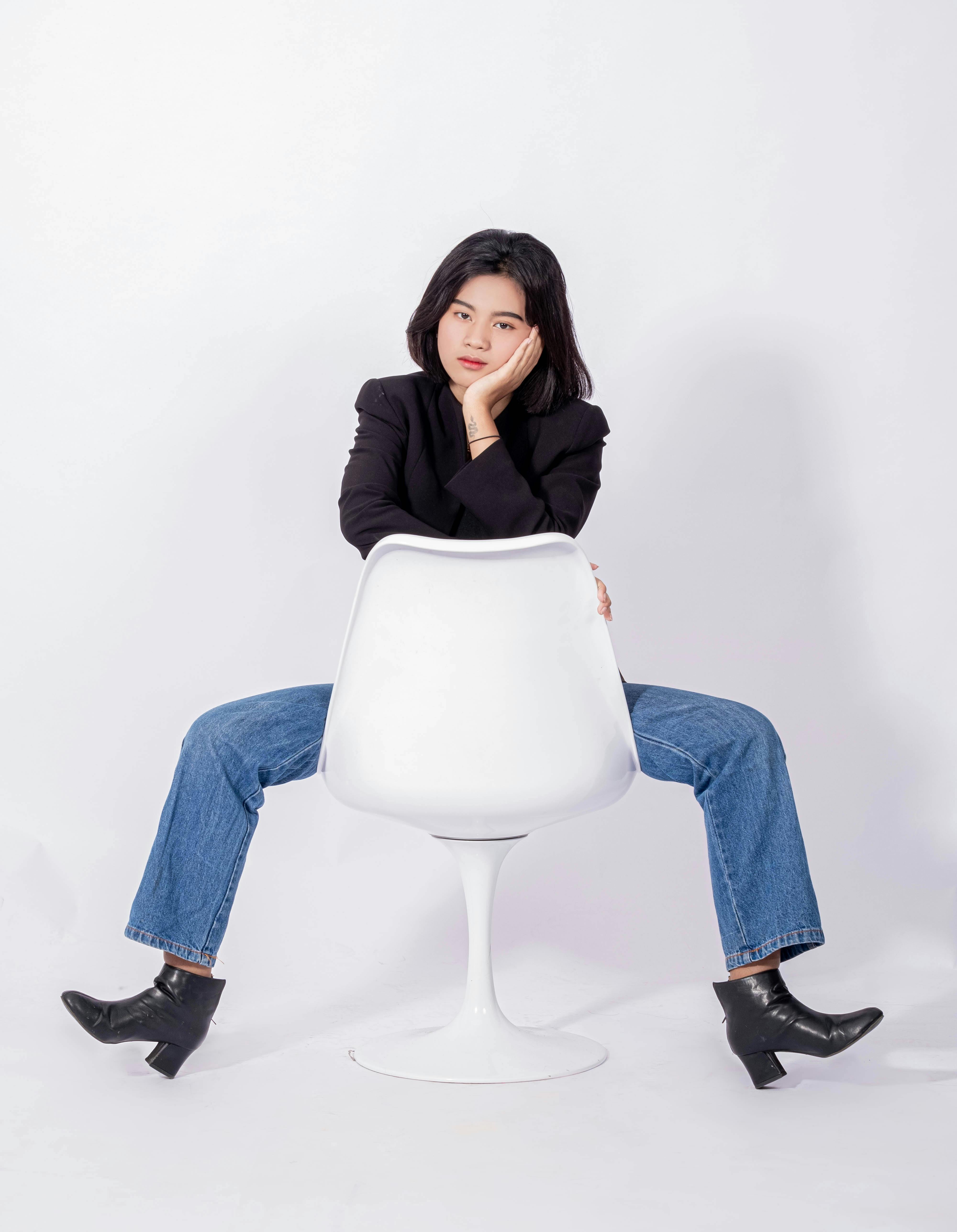 A Female Model Posing on a White Chair · Free Stock Photo