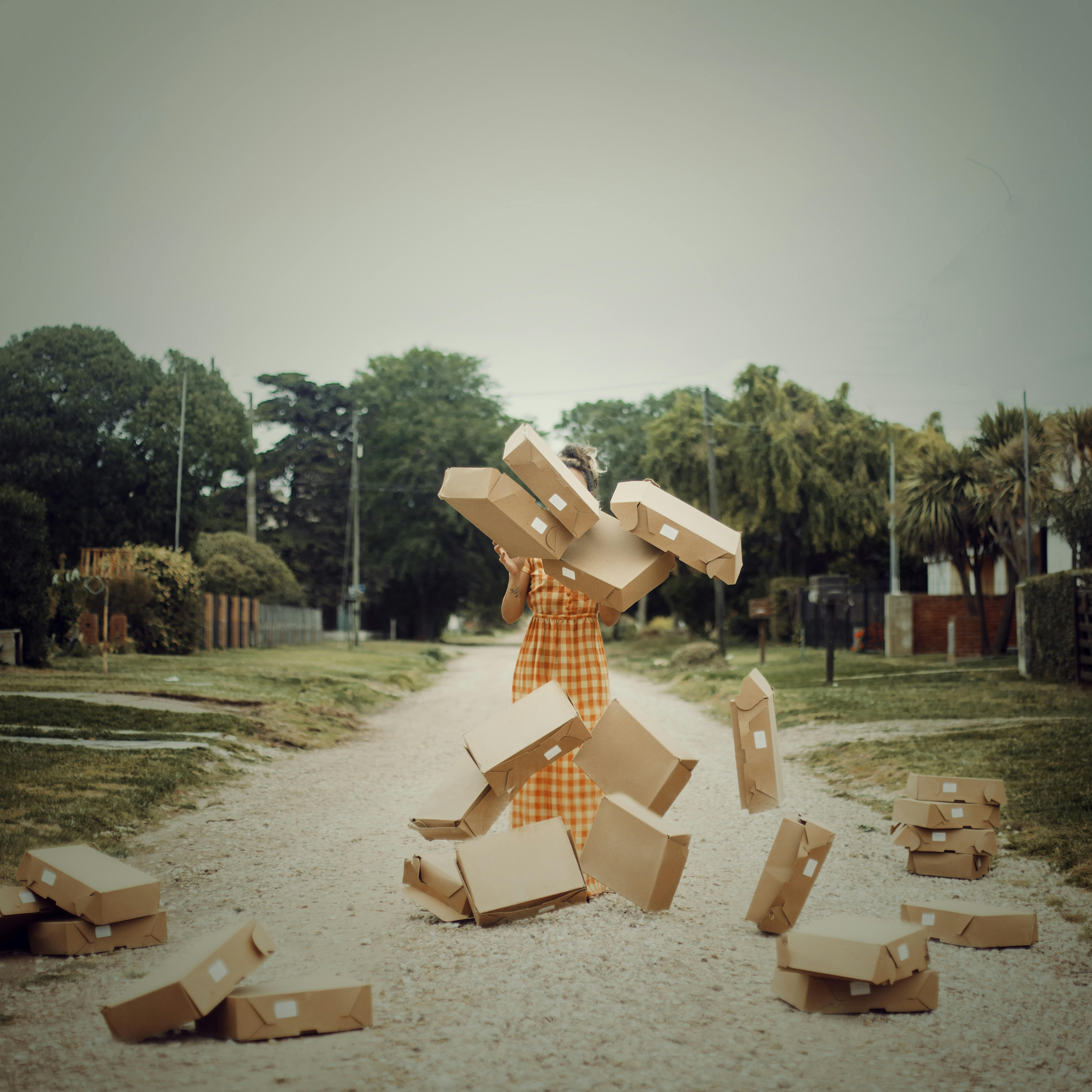 Woman with Boxes on Ground Road · Free Stock Photo