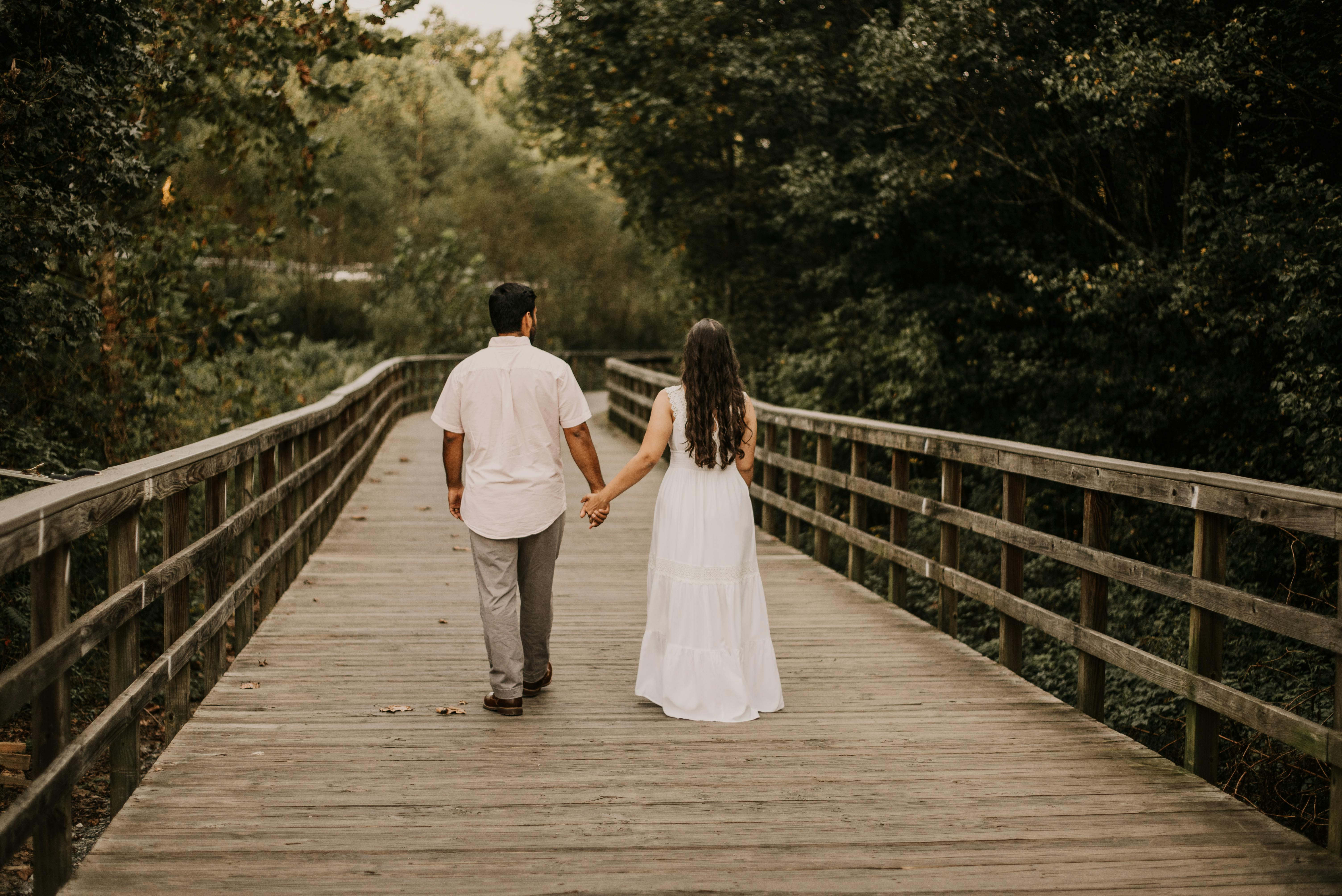 A Romantic Couple Walking on a Wooden Bridge · Free Stock Photo