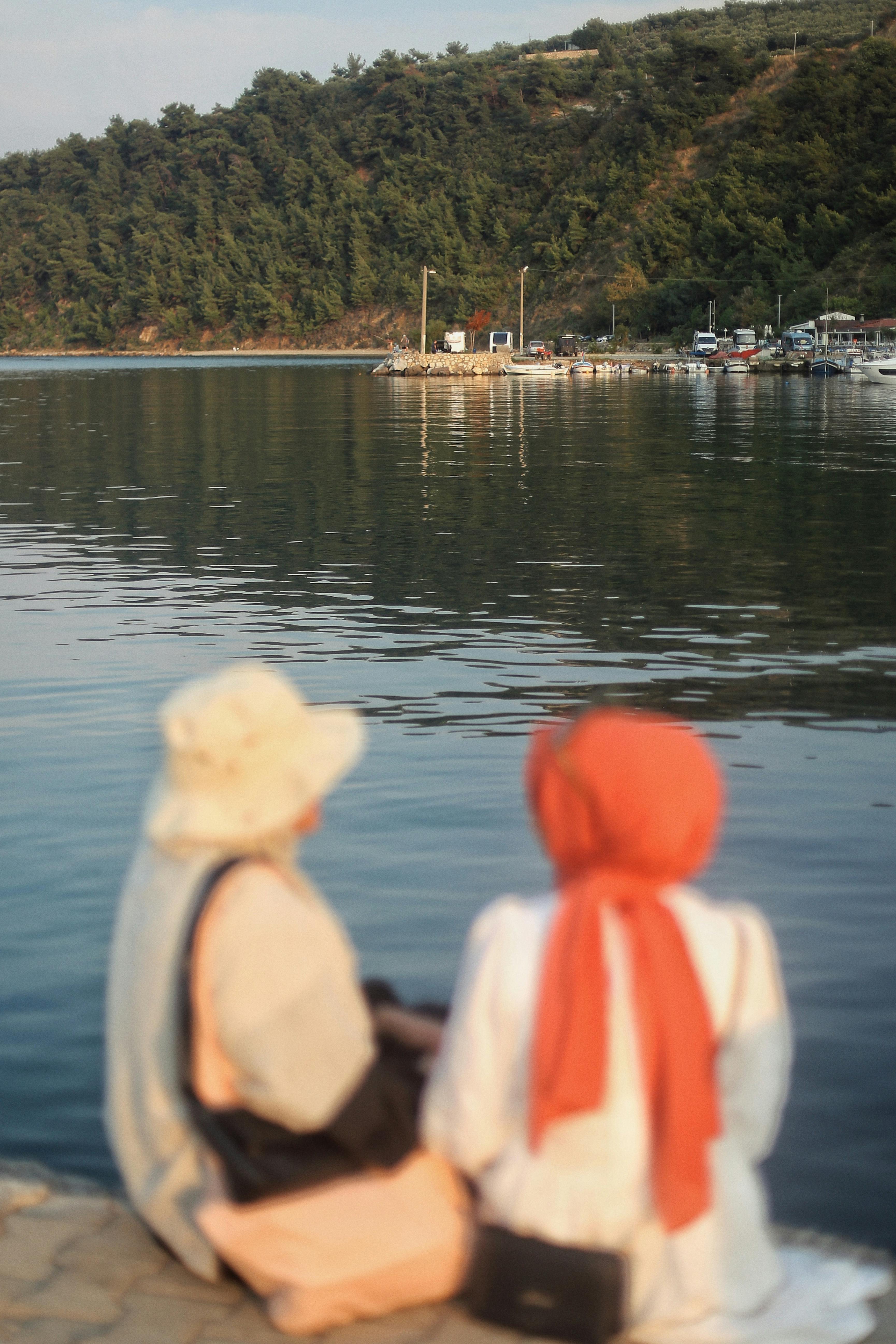 People Sitting Near Body of Water · Free Stock Photo