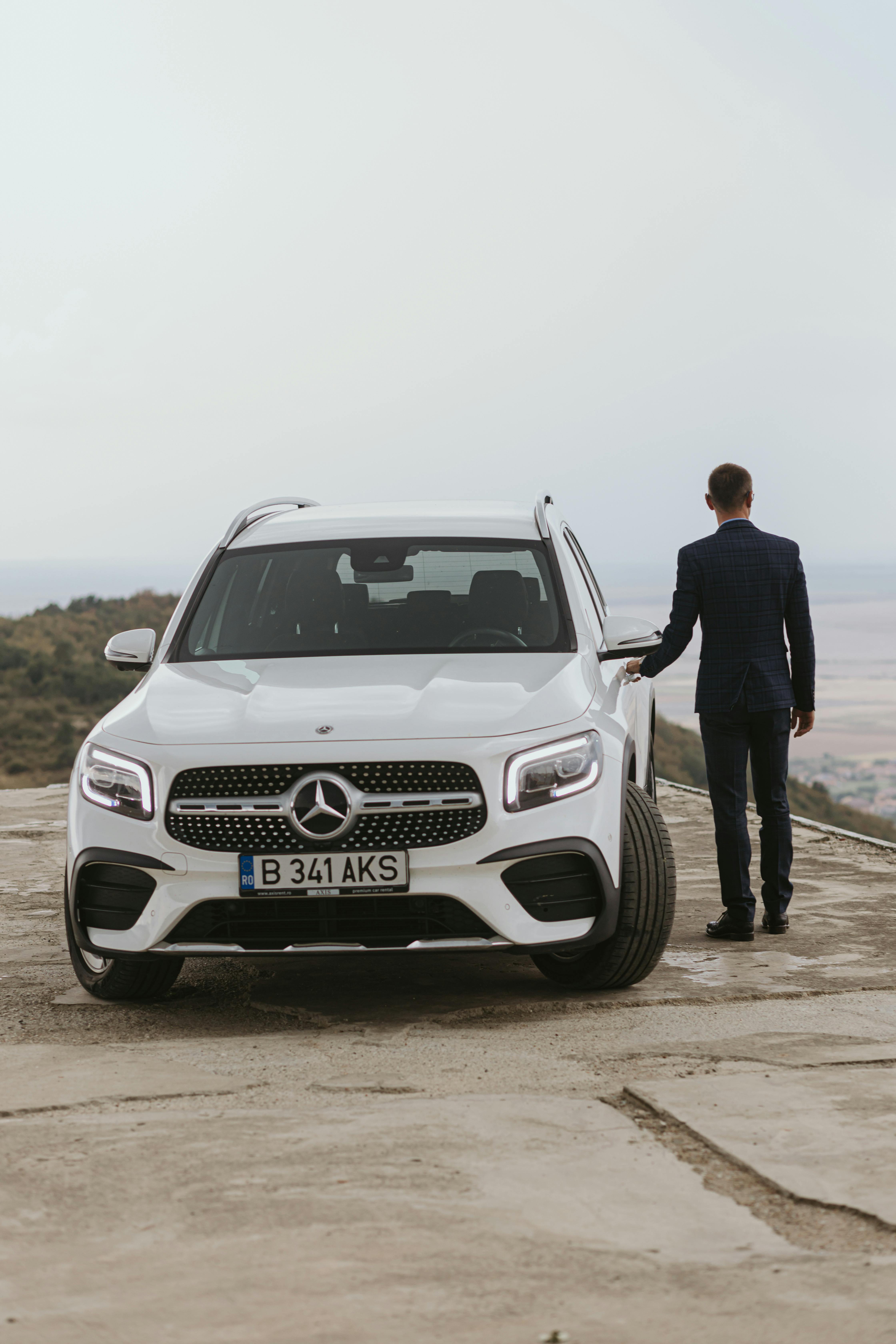 Man in Black Suit Standing Beside White Mercedes Benz Car · Free Stock ...