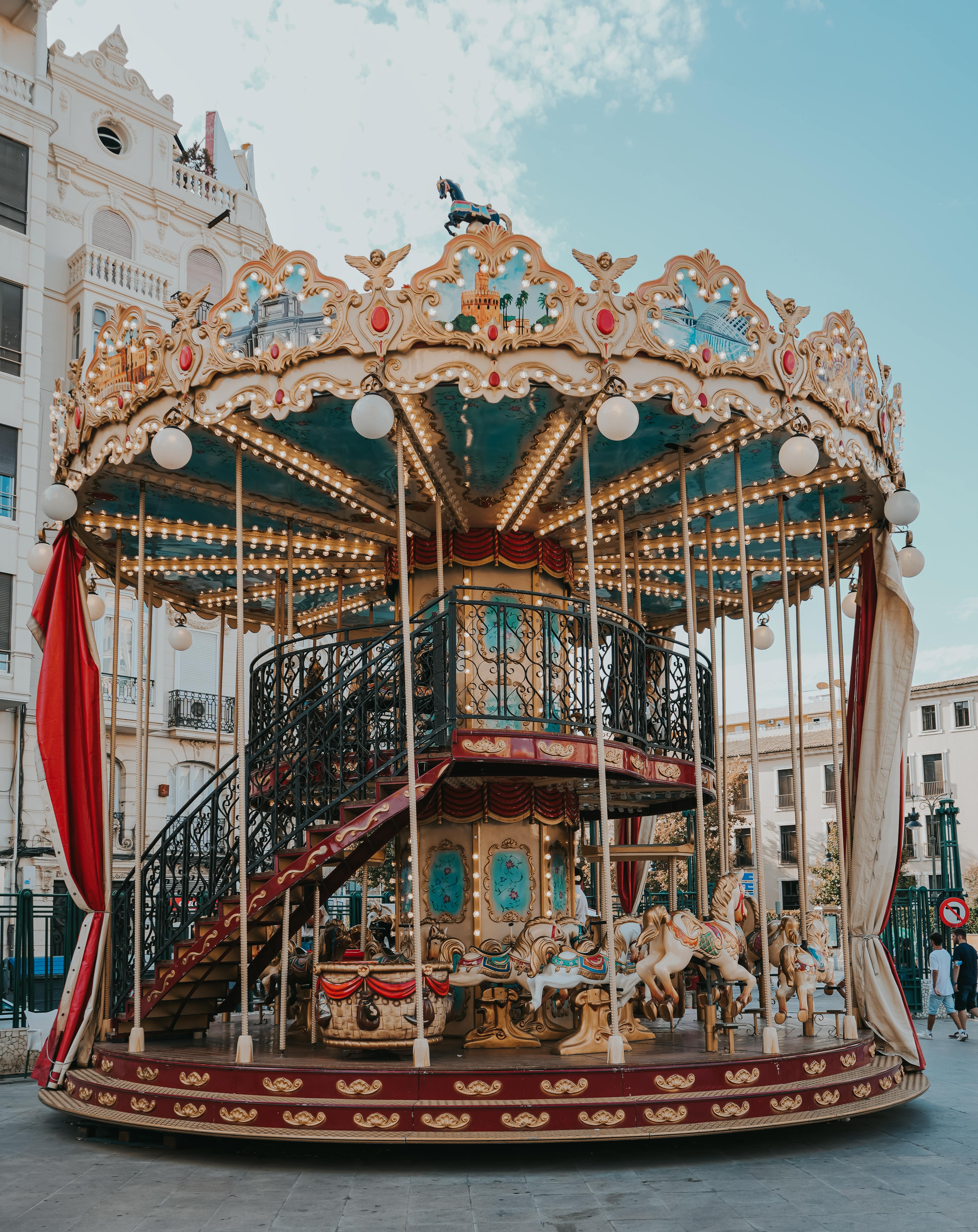 A Carousel on the Street Near White Building · Free Stock Photo