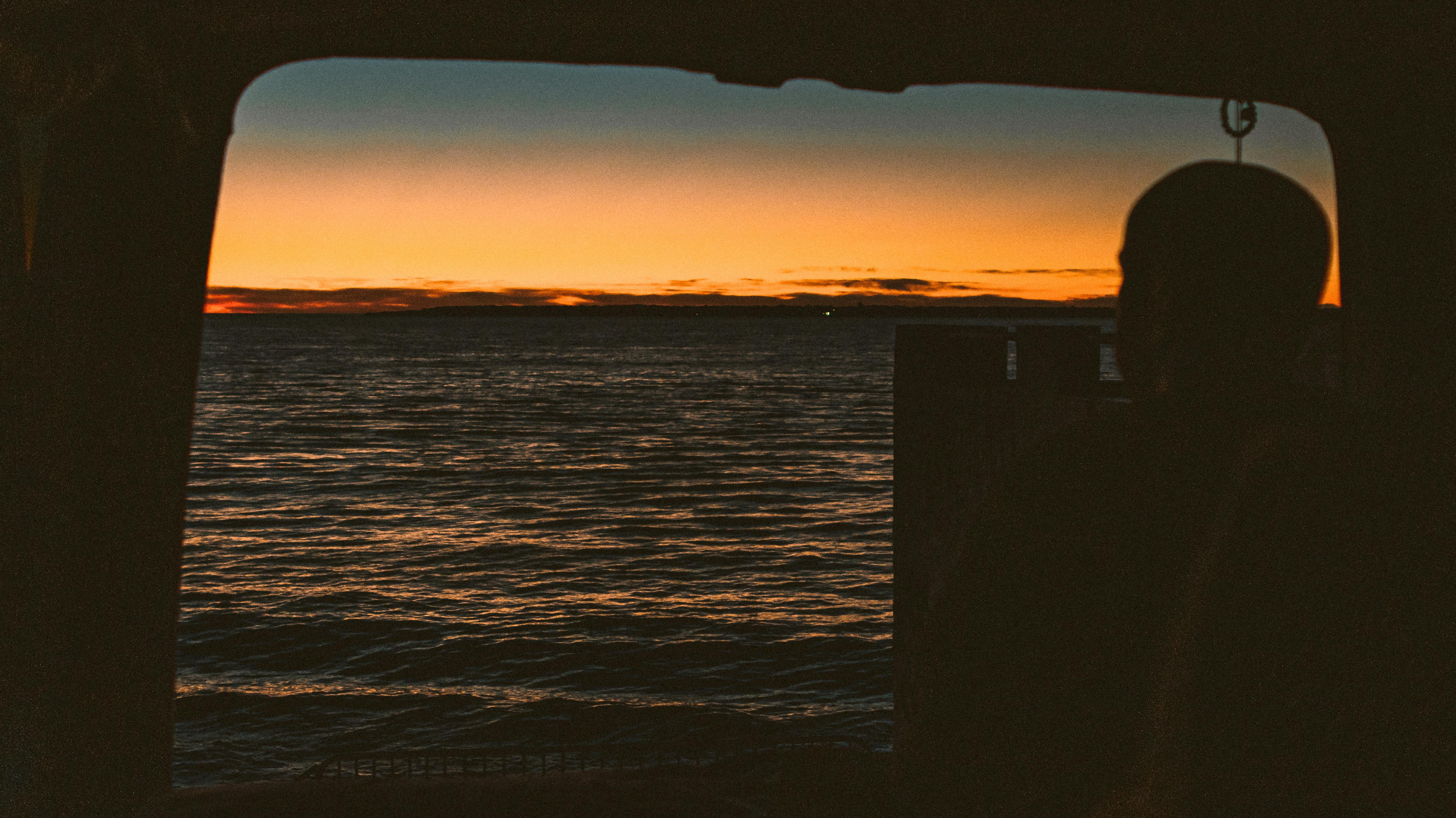 Man Looking at Sunset Above Sea · Free Stock Photo
