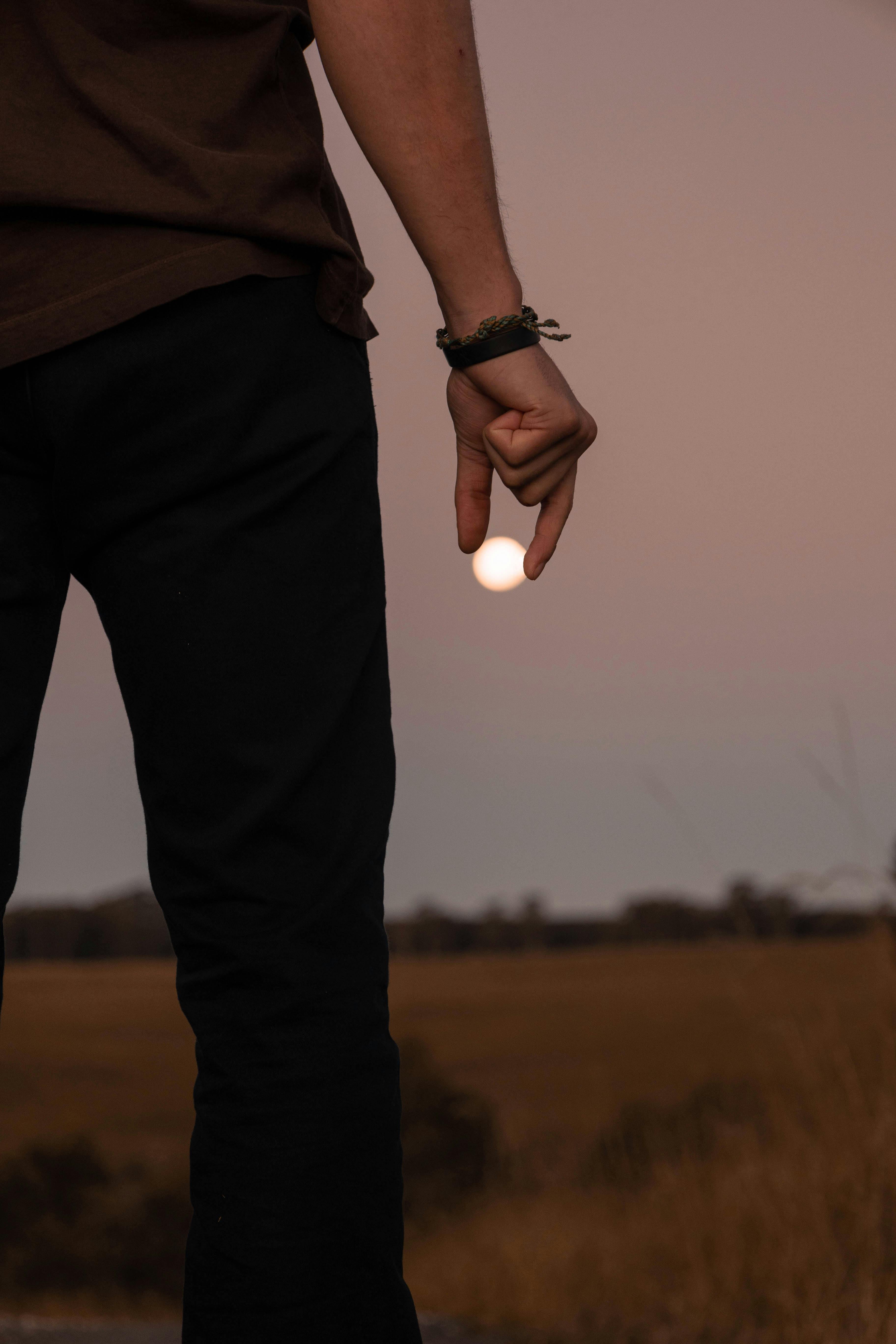 Close-up of Man Holding Moon in Fingers · Free Stock Photo