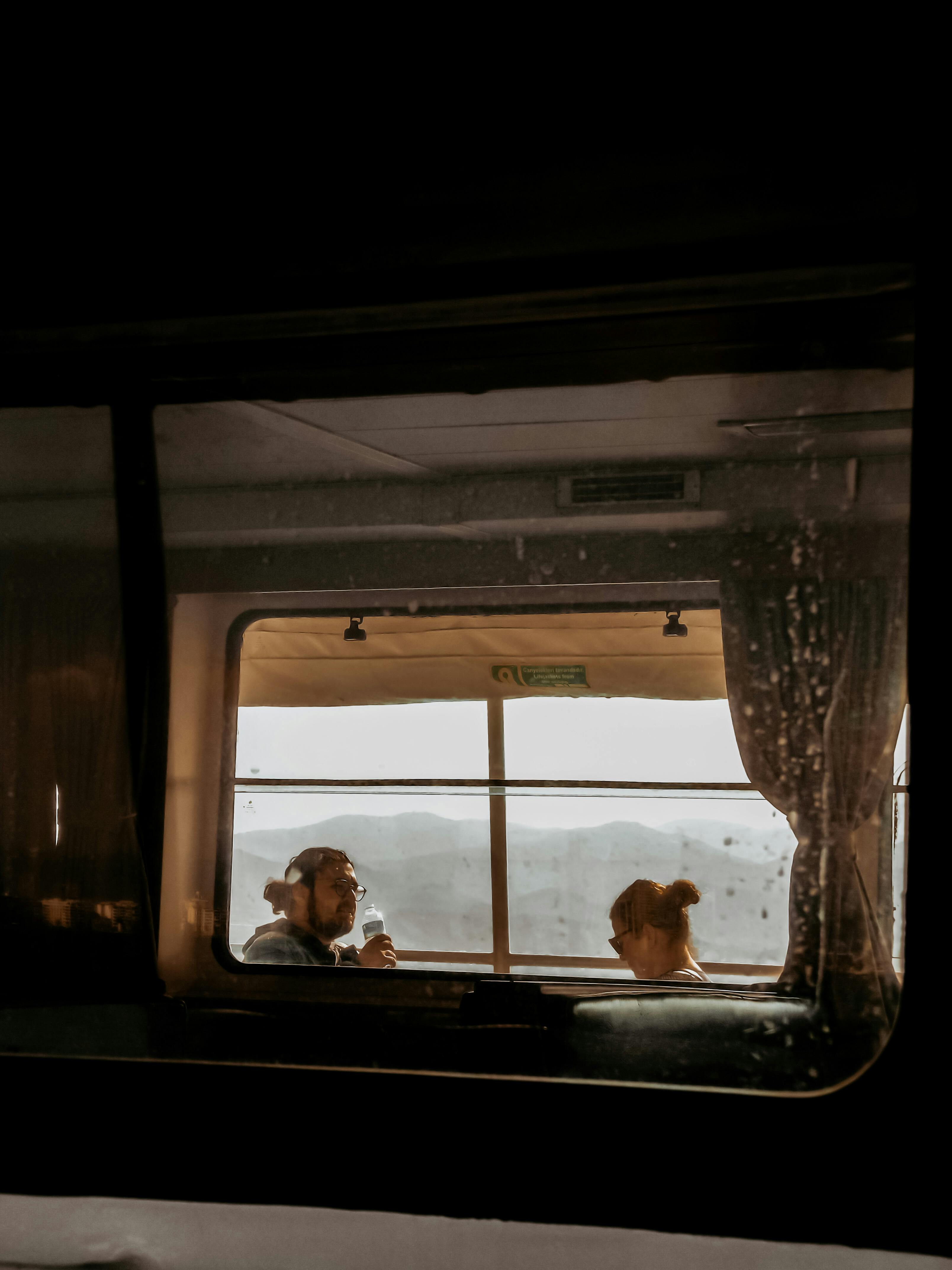 Two Passengers Sitting on a Train Facing Each Other · Free Stock Photo
