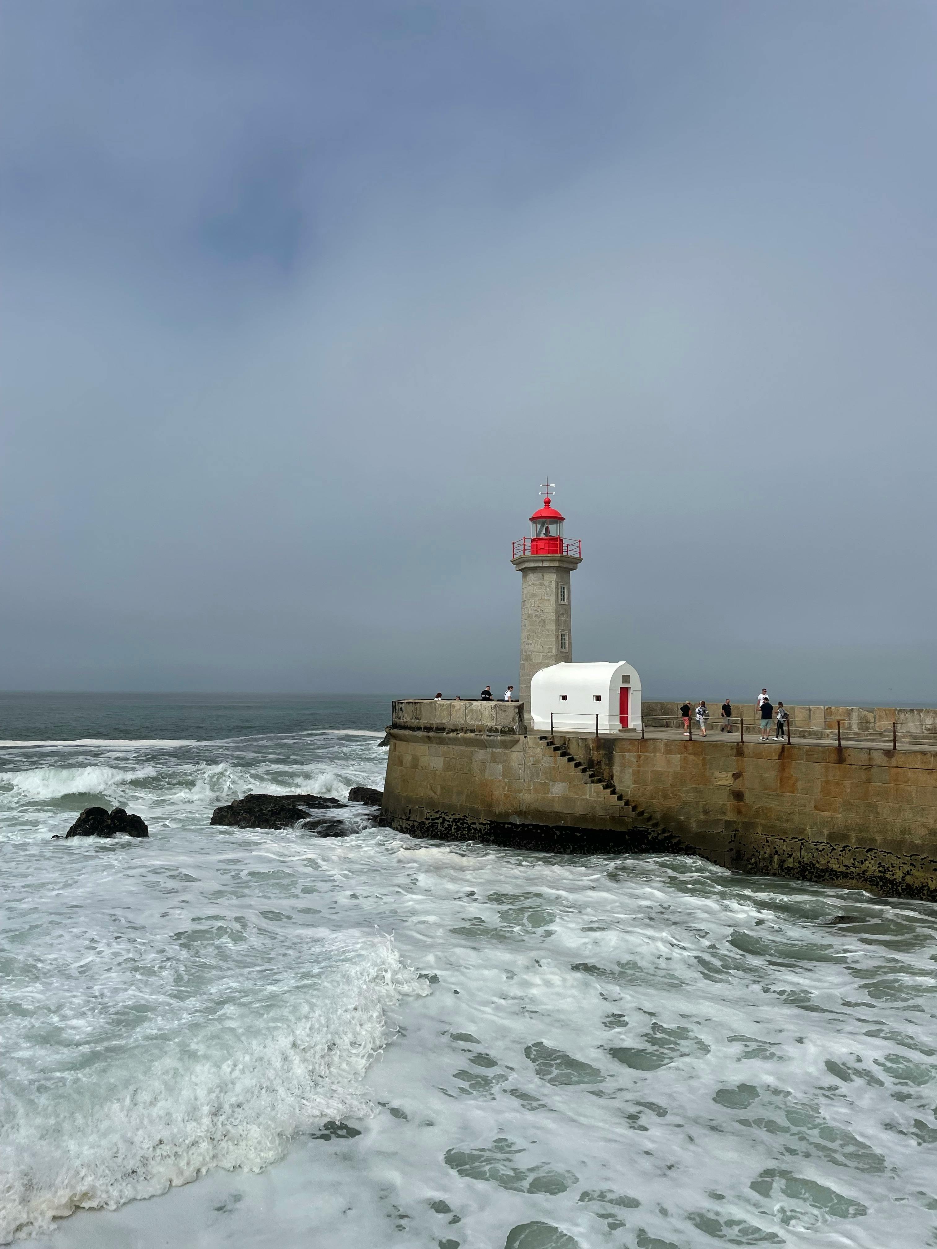Lighthouse at End of Pier Extending into Sea · Free Stock Photo