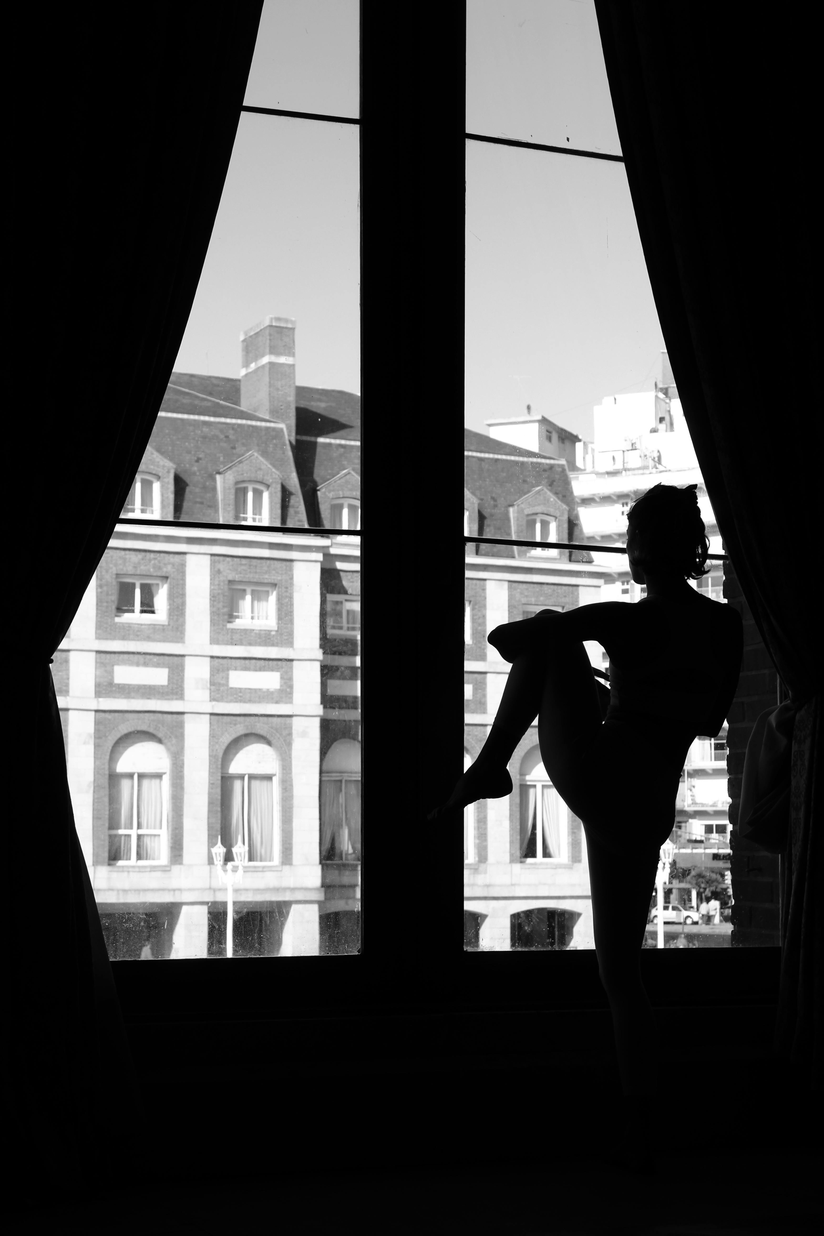 Silhouette of Person Standing near the Glass Window · Free Stock Photo