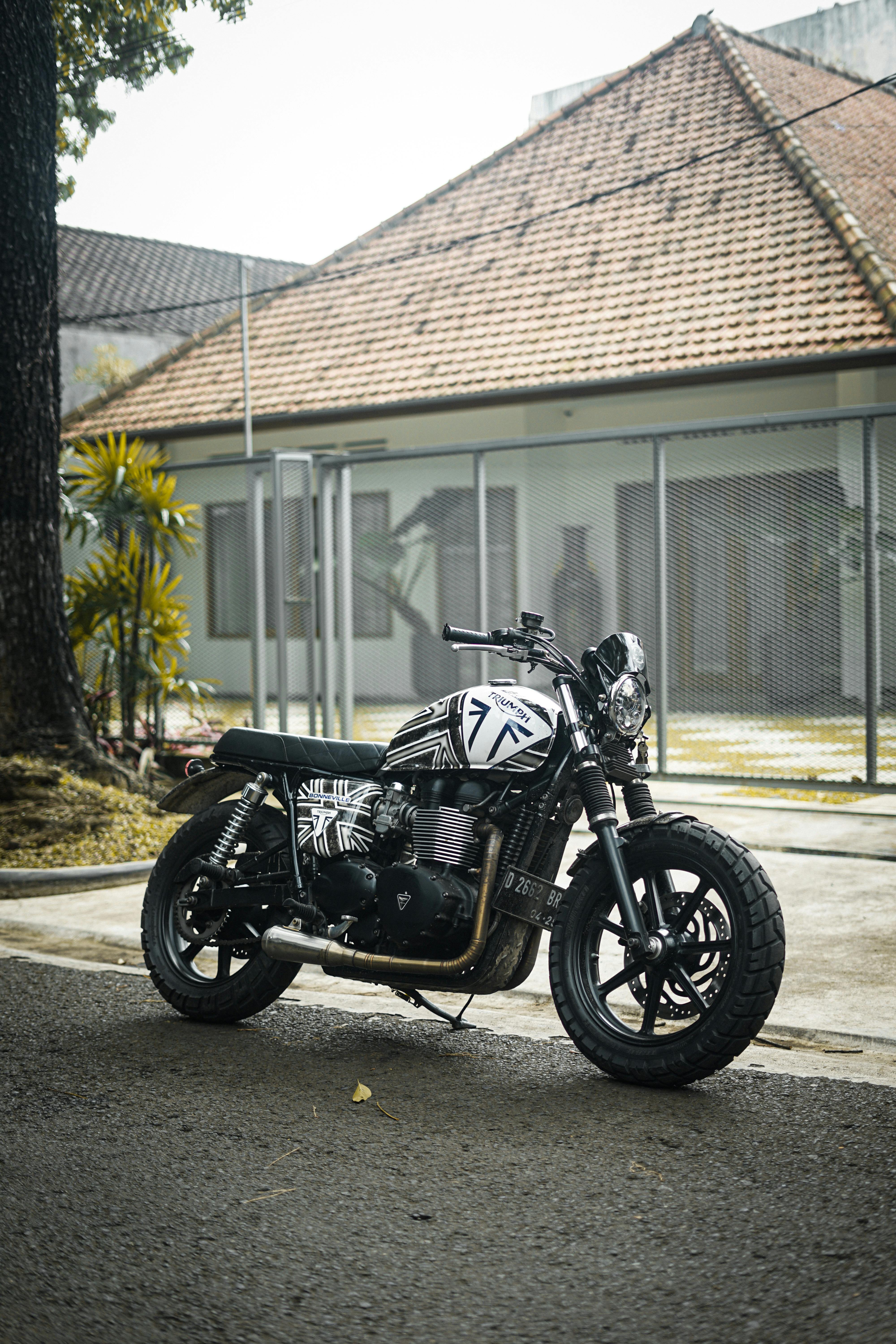 Motorcycle Parked Near a Metal Gate · Free Stock Photo