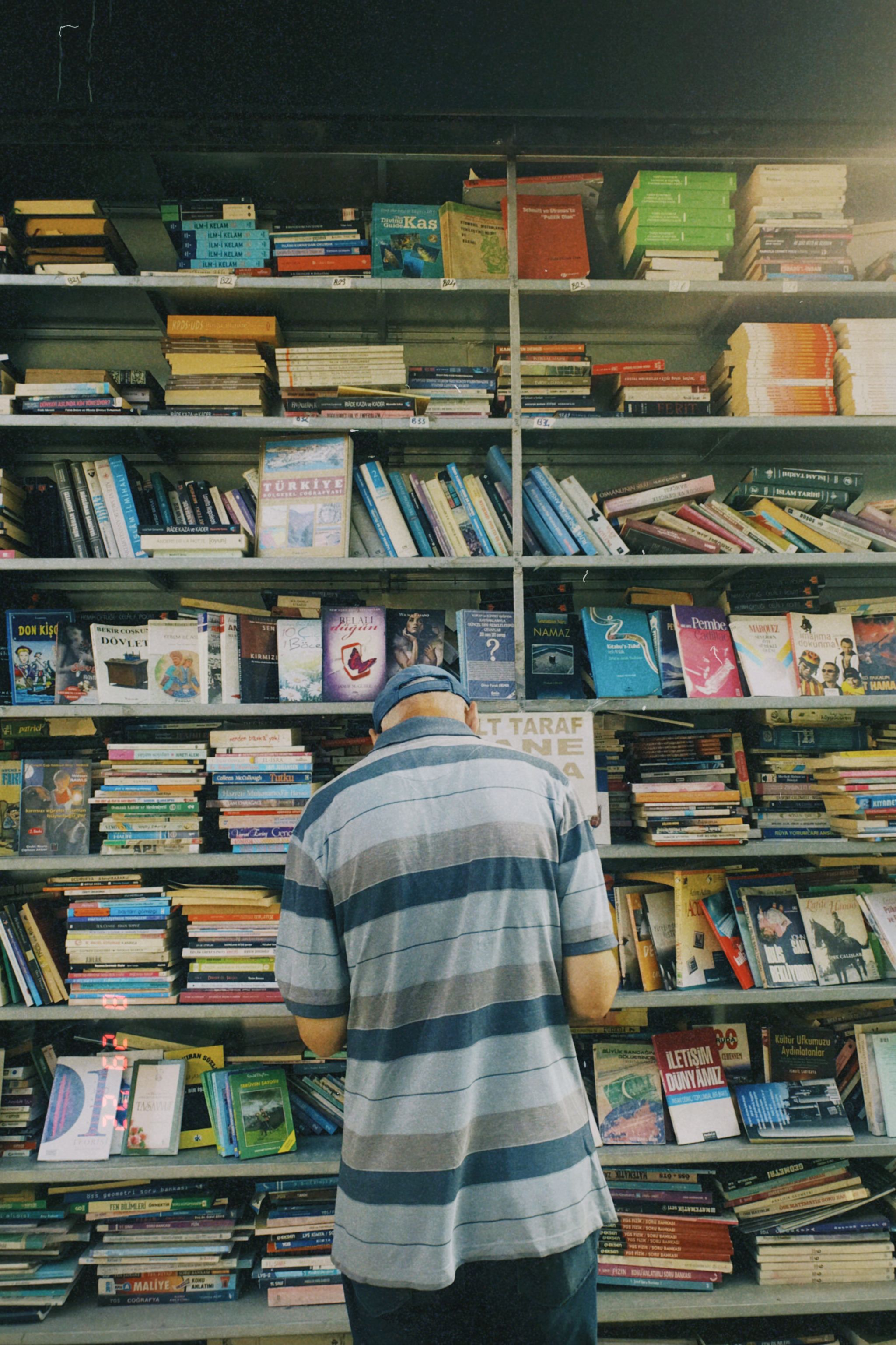 Man Standing in Front of a Bookcase · Free Stock Photo