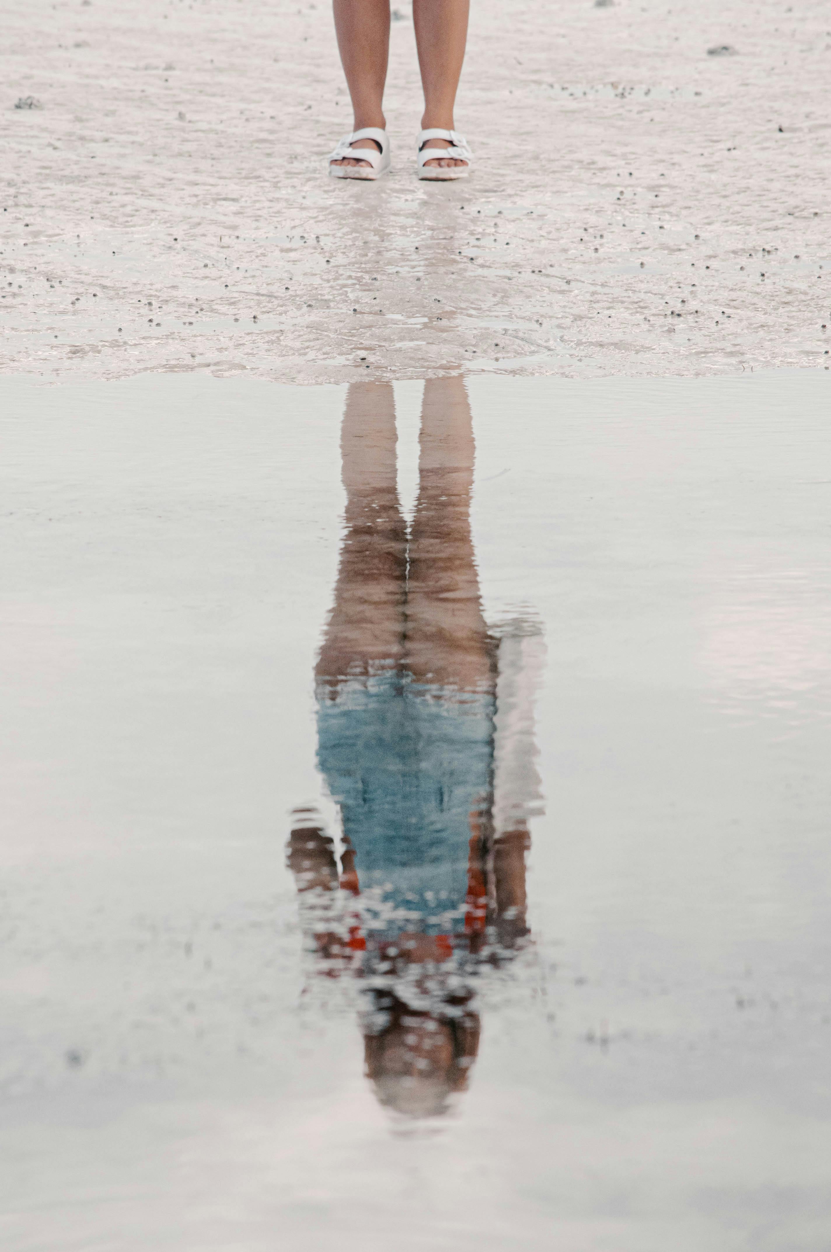 Reflection of Woman in Water on the Ground · Free Stock Photo