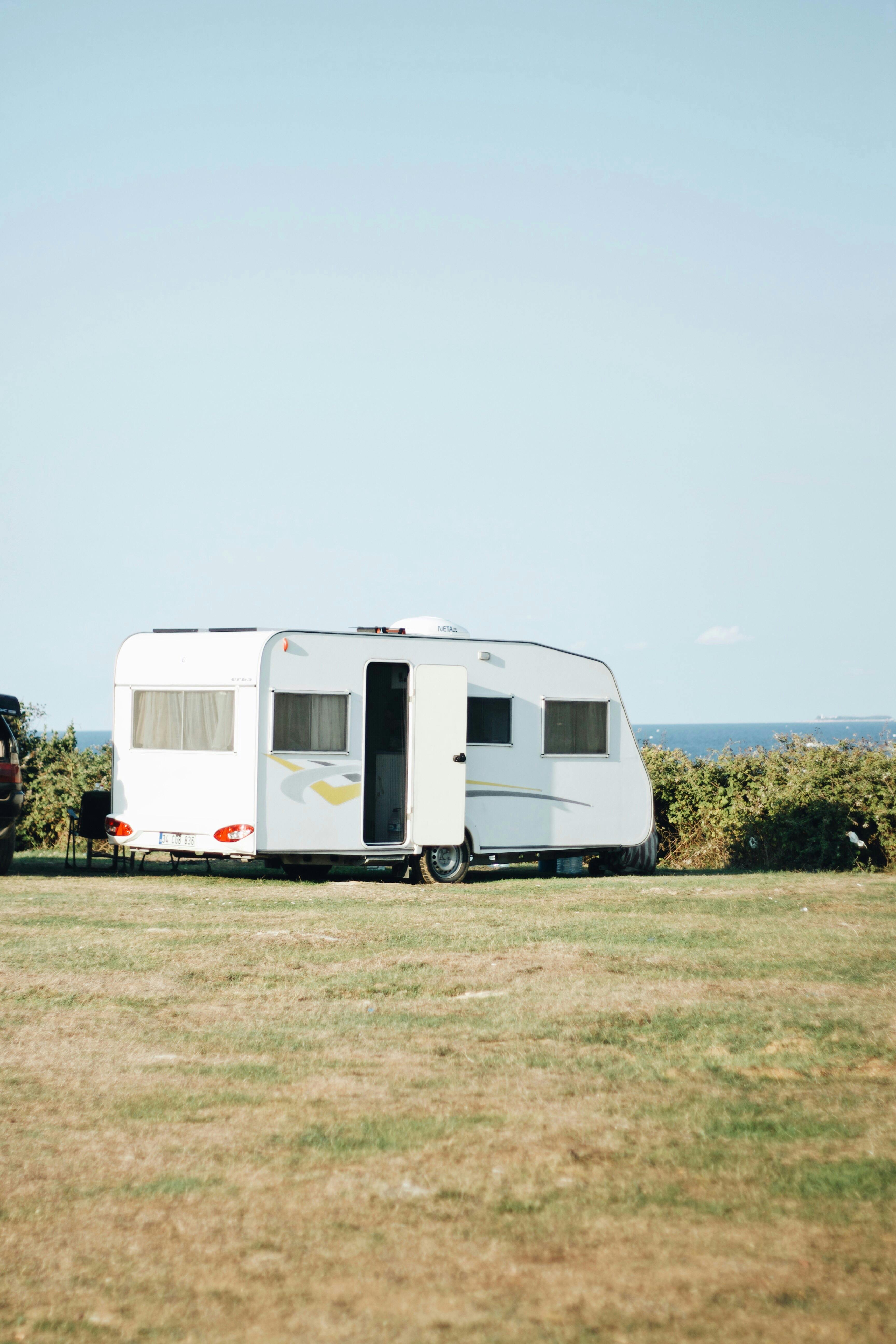 Red Camper Trailer Parked by Wall · Free Stock Photo