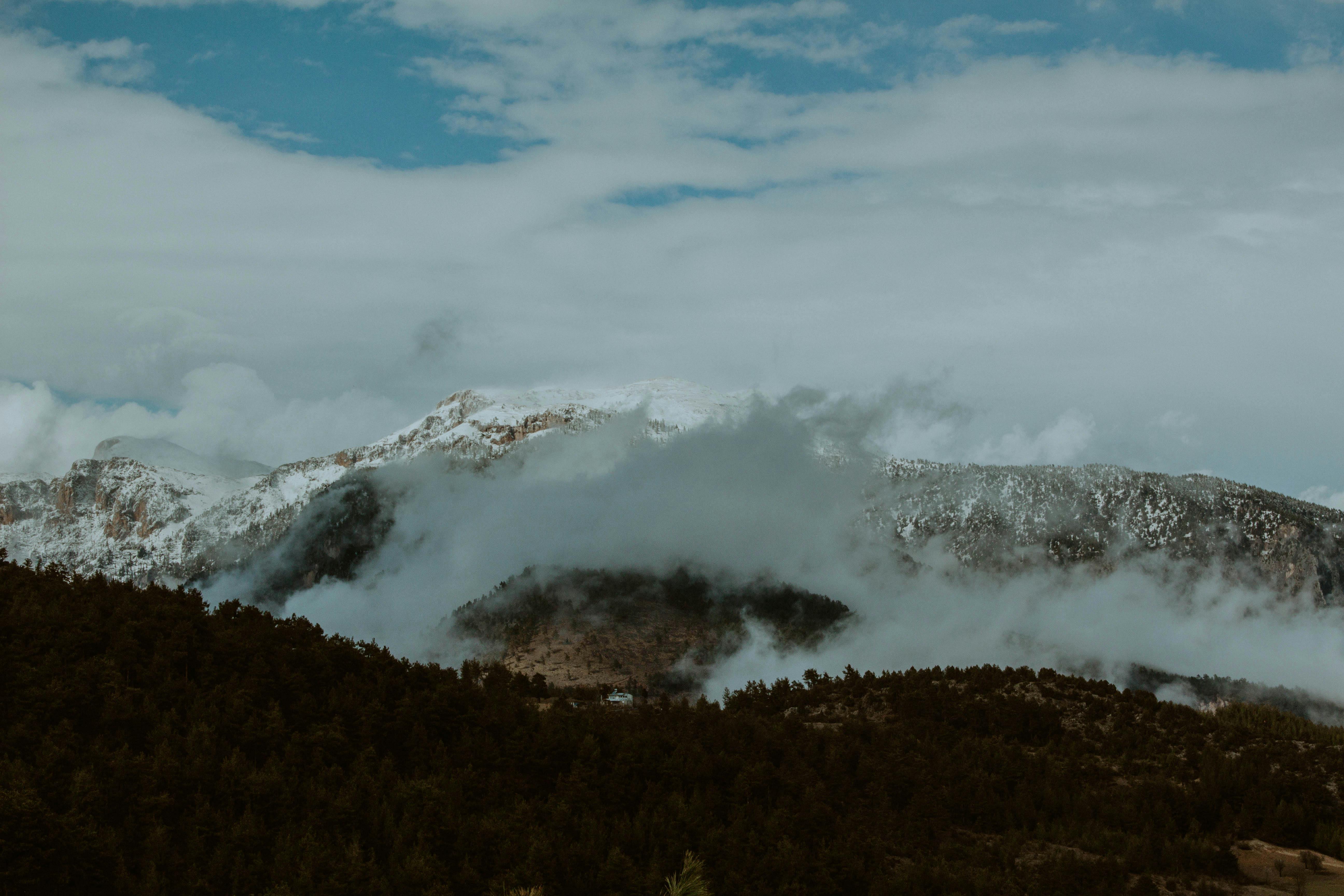 Fog Covered a Snow Capped Mountain · Free Stock Photo