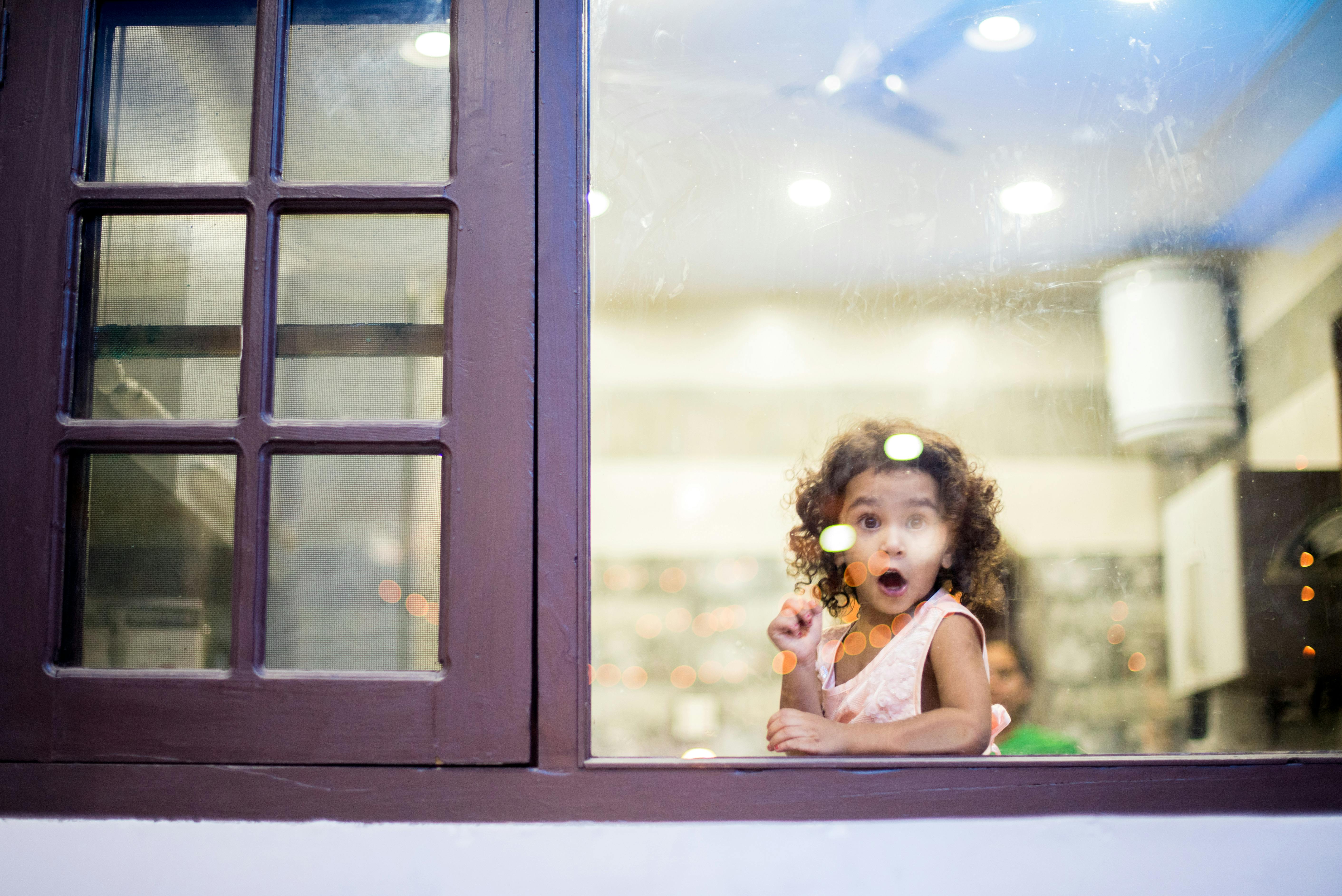 Girl Behind Glass Window · Free Stock Photo