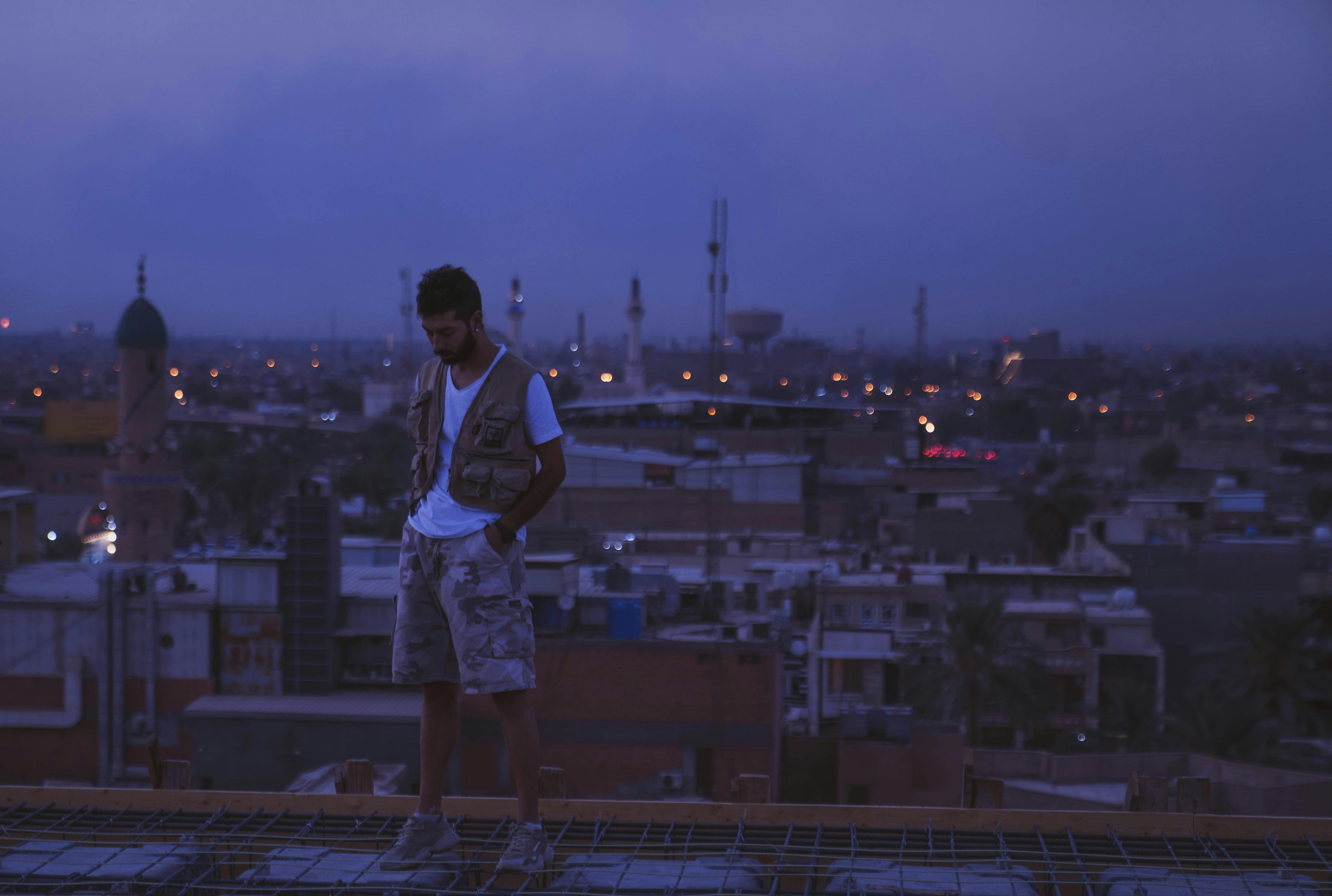 Man Standing on Building Roof on Sunset · Free Stock Photo