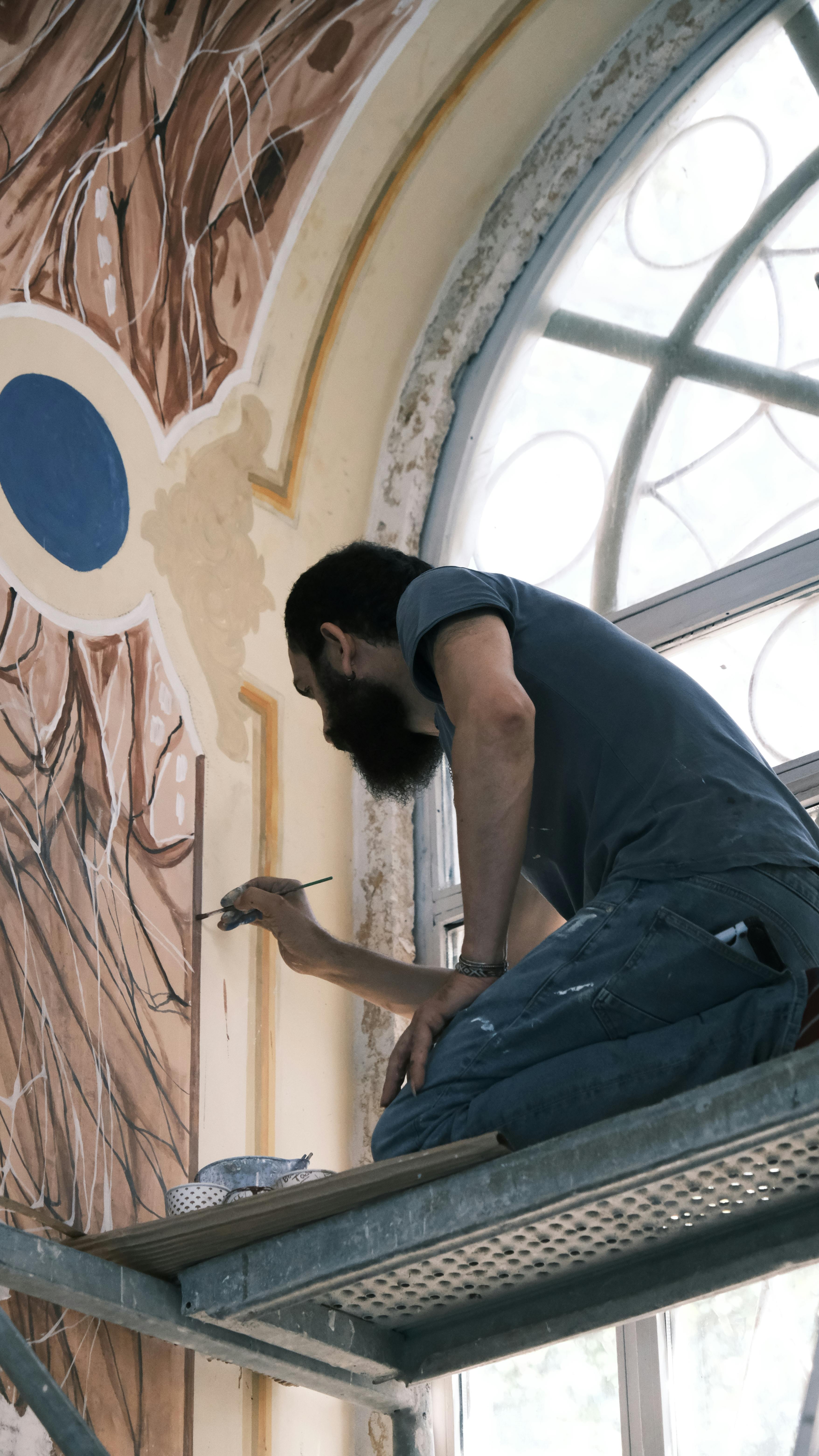 Man Painting a Wall Beside a Window · Free Stock Photo
