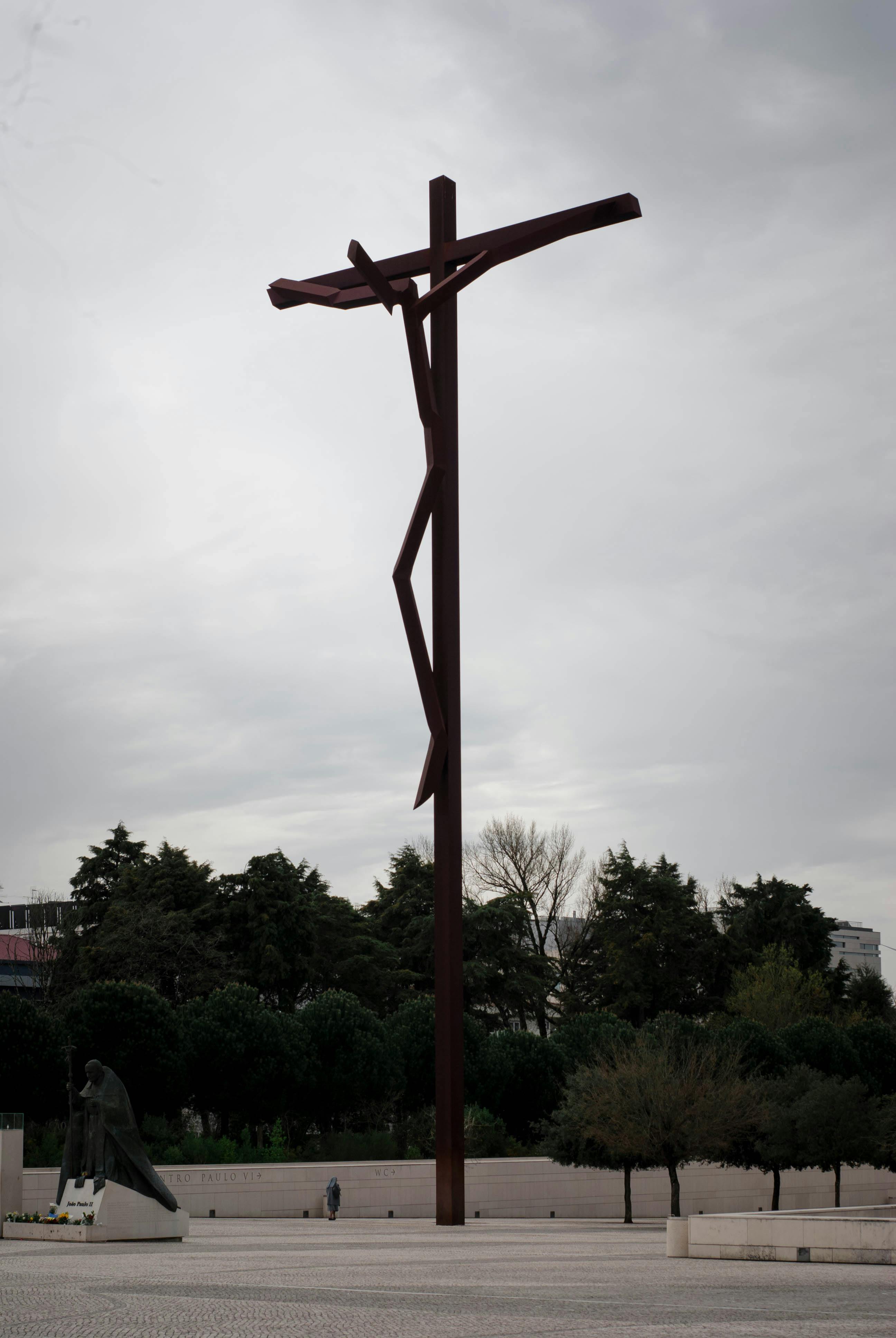 A Statue of a Person Carrying a Cross · Free Stock Photo