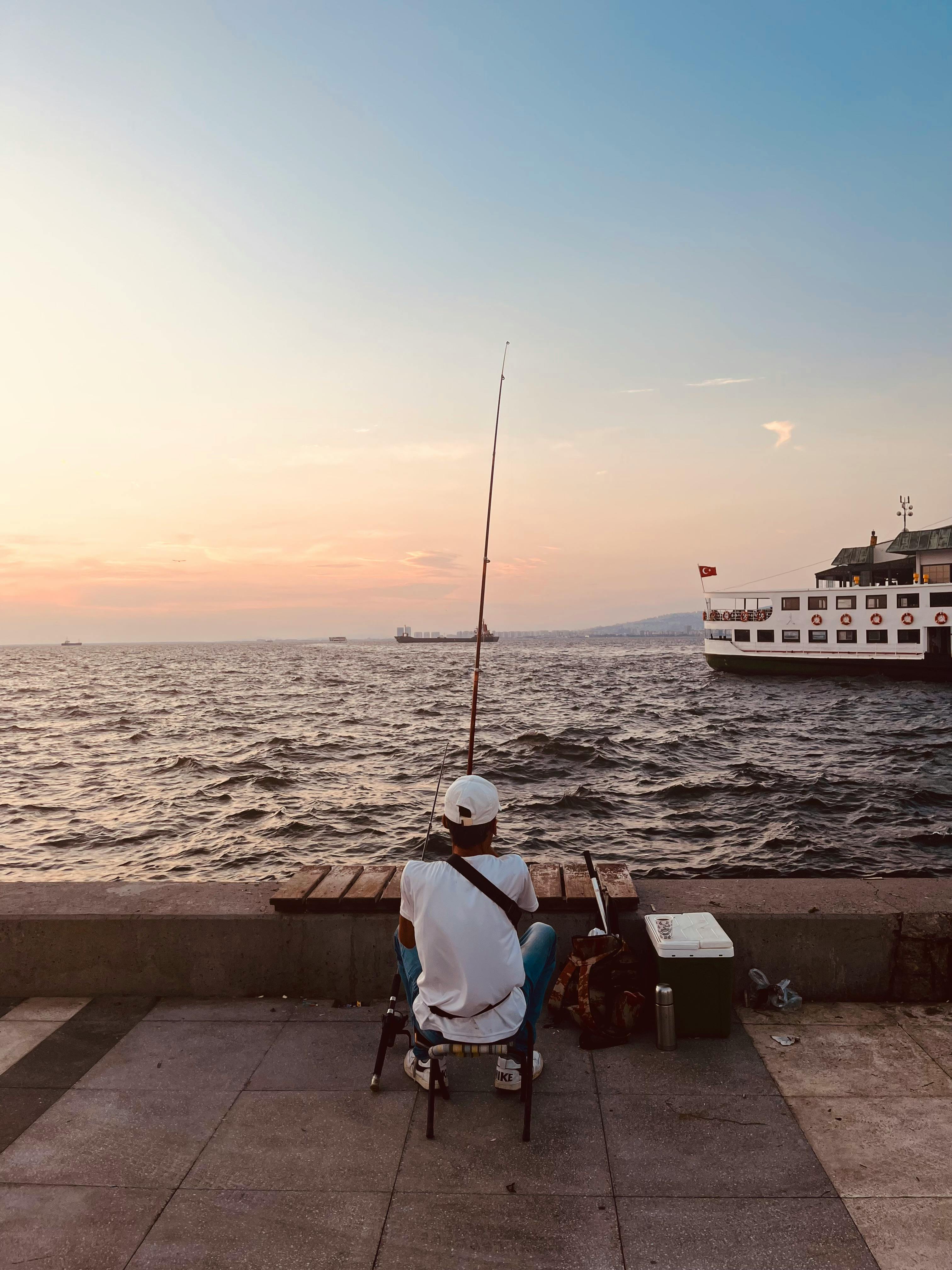 Sitting Angler Fishing at the Sea · Free Stock Photo
