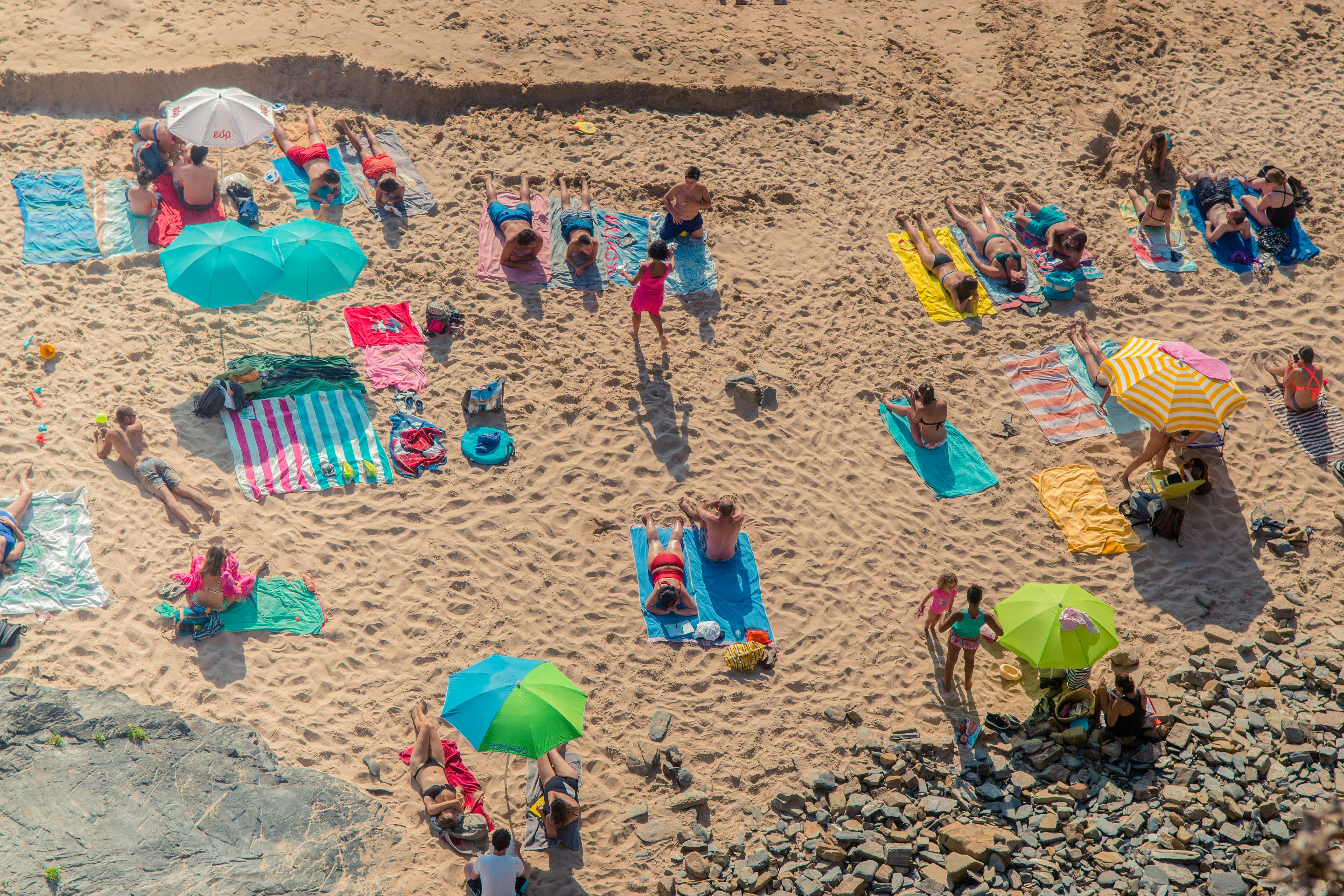 Aerial Shot of People Sunbathing at The Beach · Free Stock Photo