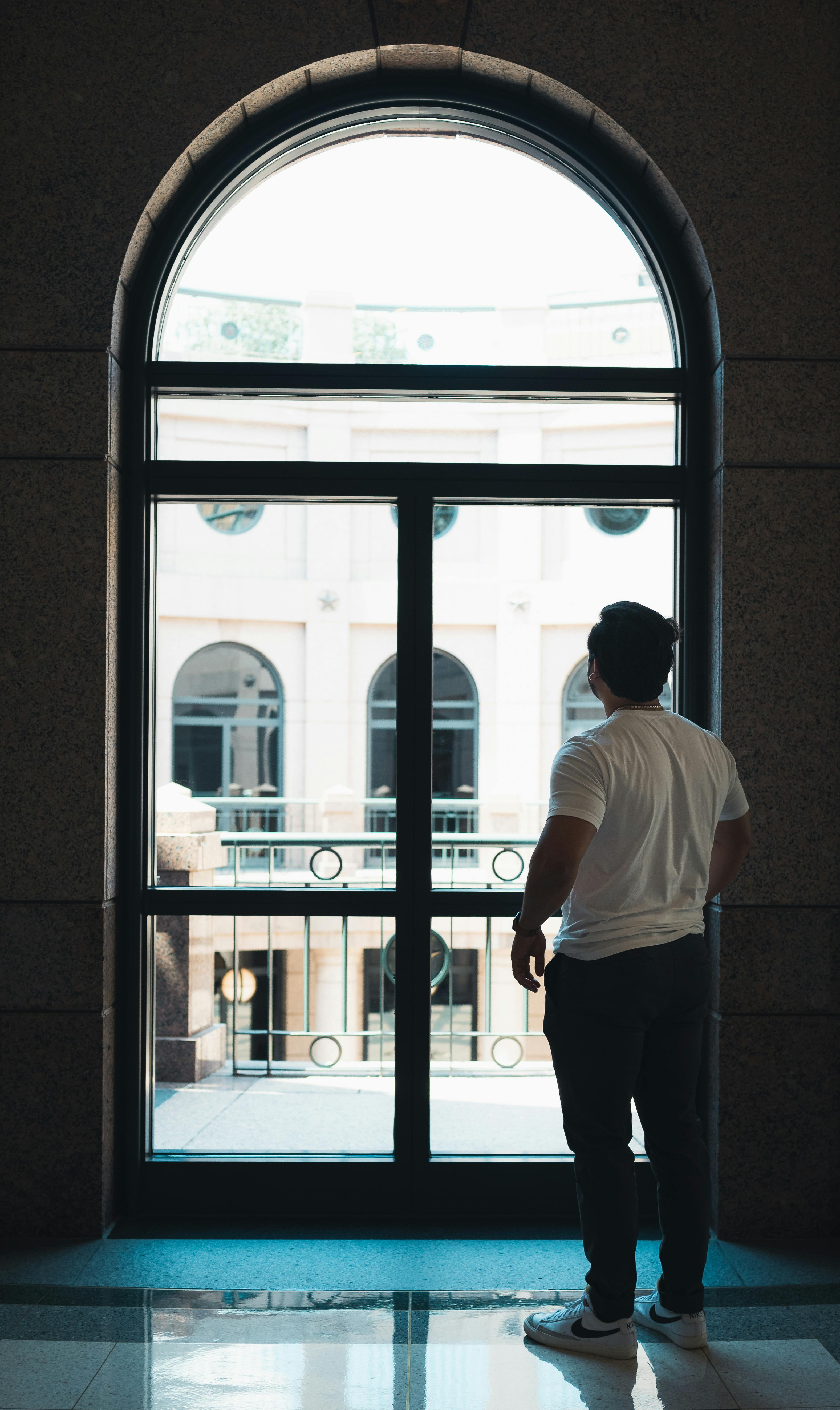 Woman in Brow Blazer Standing Beside a Window · Free Stock Photo