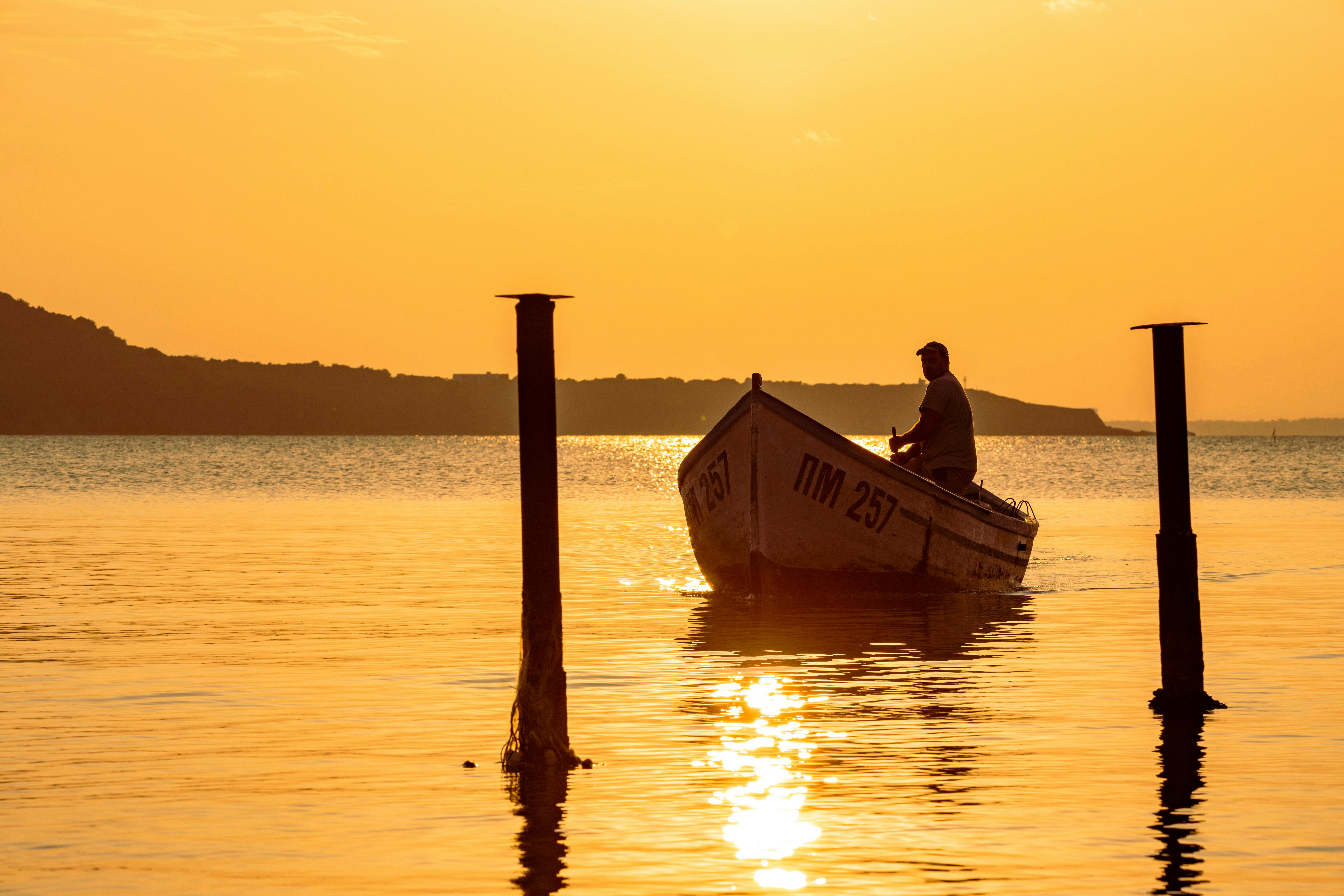 Man Riding a Boat on the Ocean during Sunset · Free Stock Photo