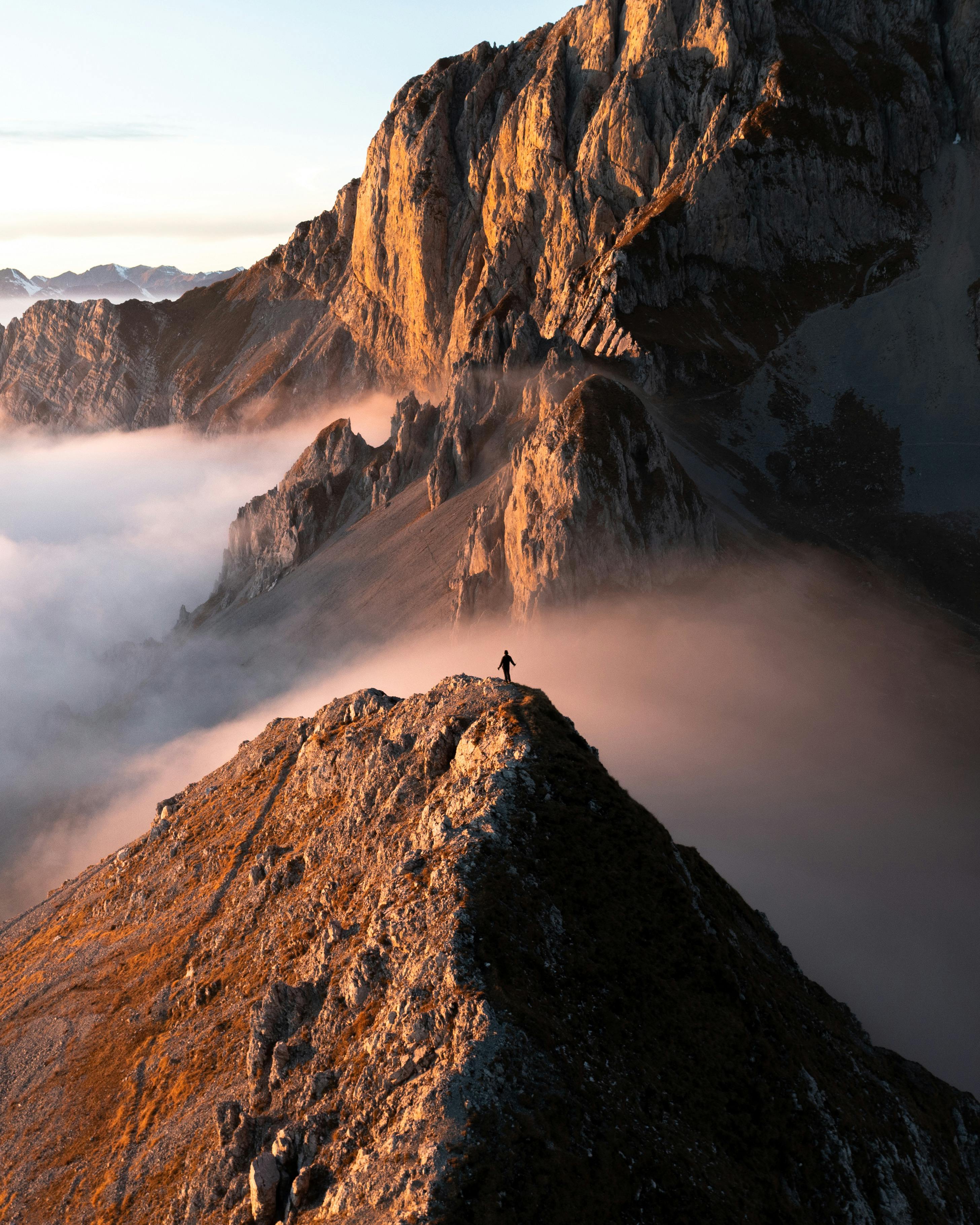 Aerial View Person on Top of a Rocky Mountain Above the Clouds · Free ...