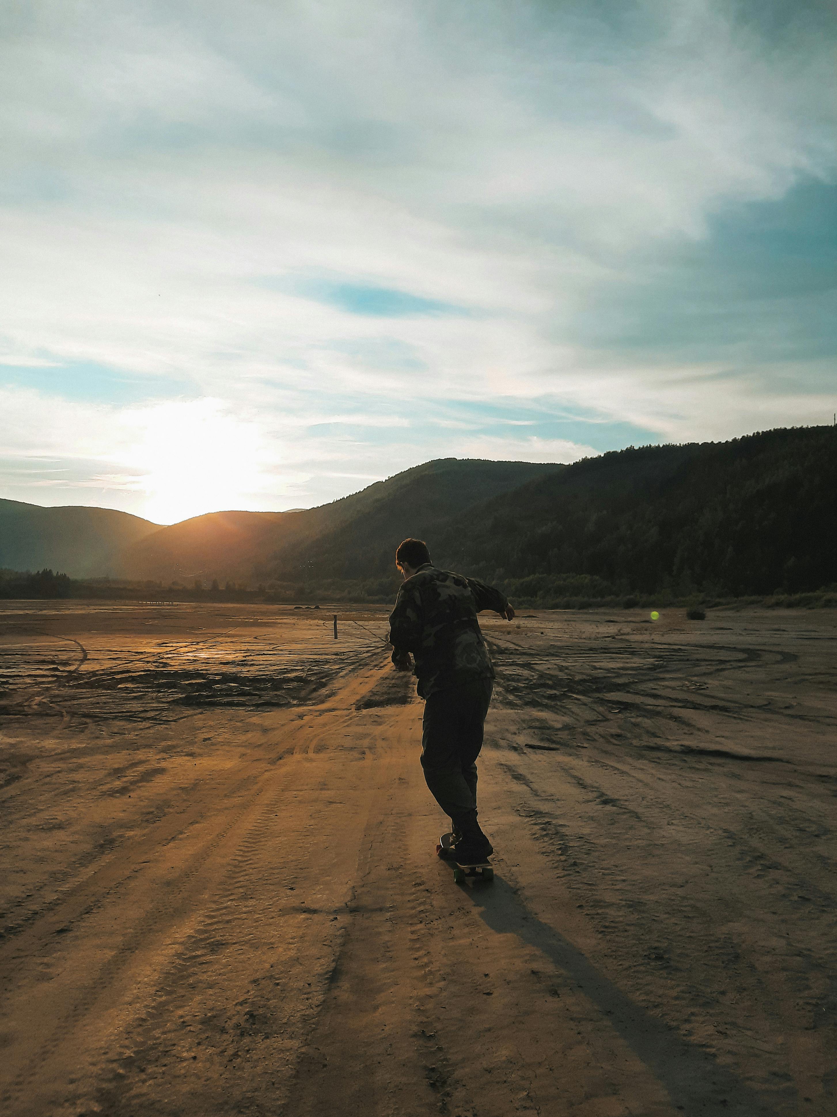 Man Playing a Skateboard on Sand · Free Stock Photo