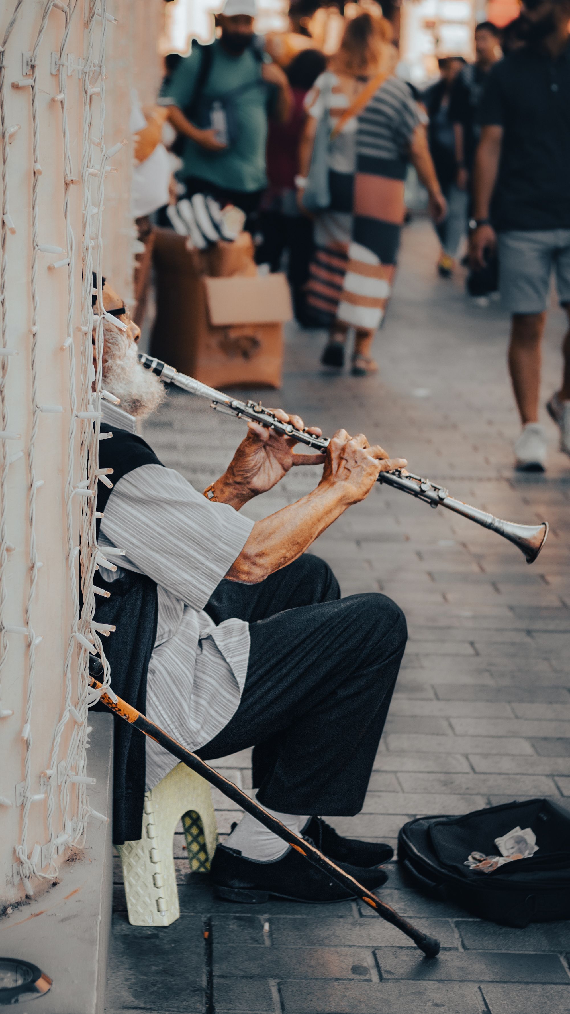 A Man Playing a Wind Instrument on a Sidewalk · Free Stock Photo