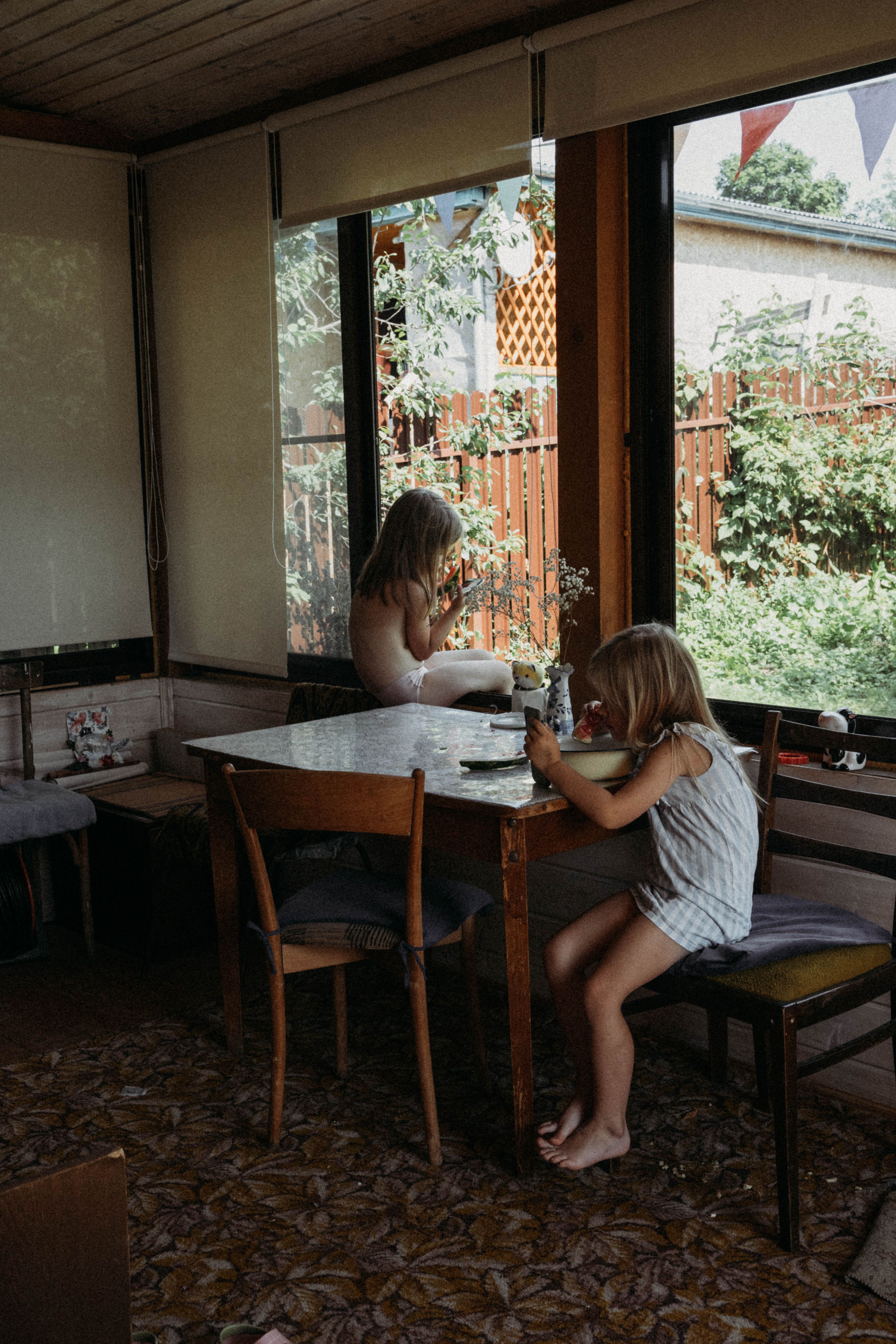 Young Girls Passing Plates at a Dining Table · Free Stock Photo