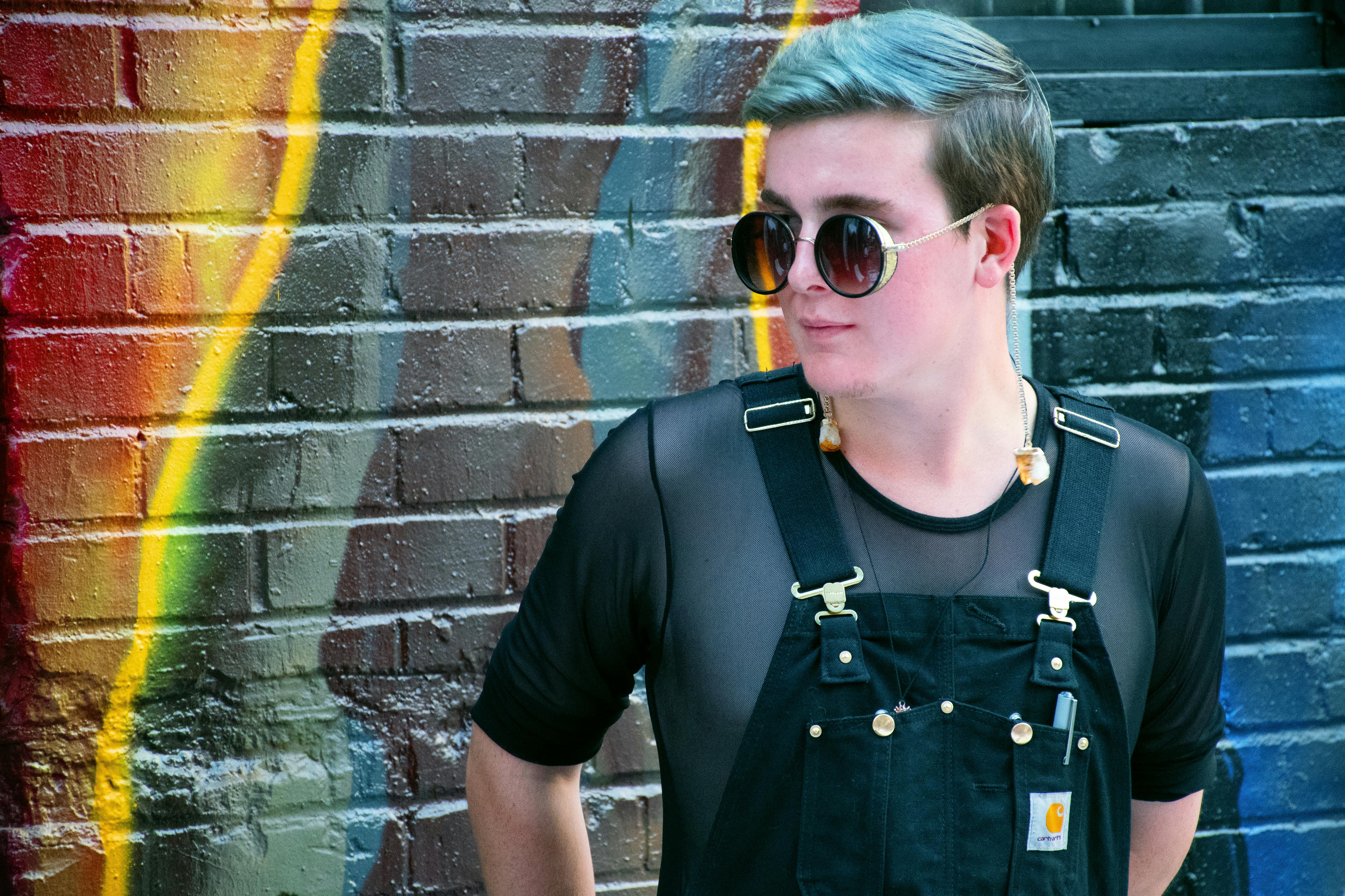 Man Facing Sideways Standing Near Multicolored Wall · Free Stock Photo