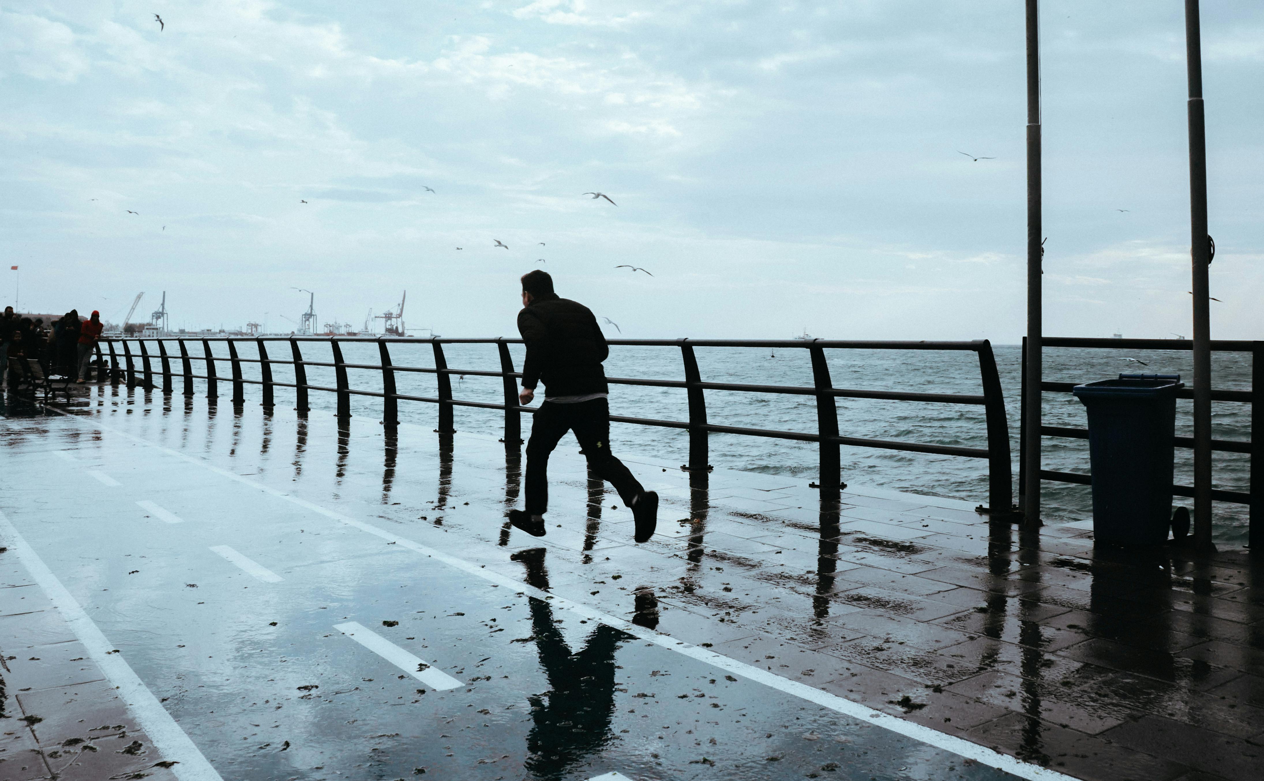 A Person Running on a Wet Dock · Free Stock Photo