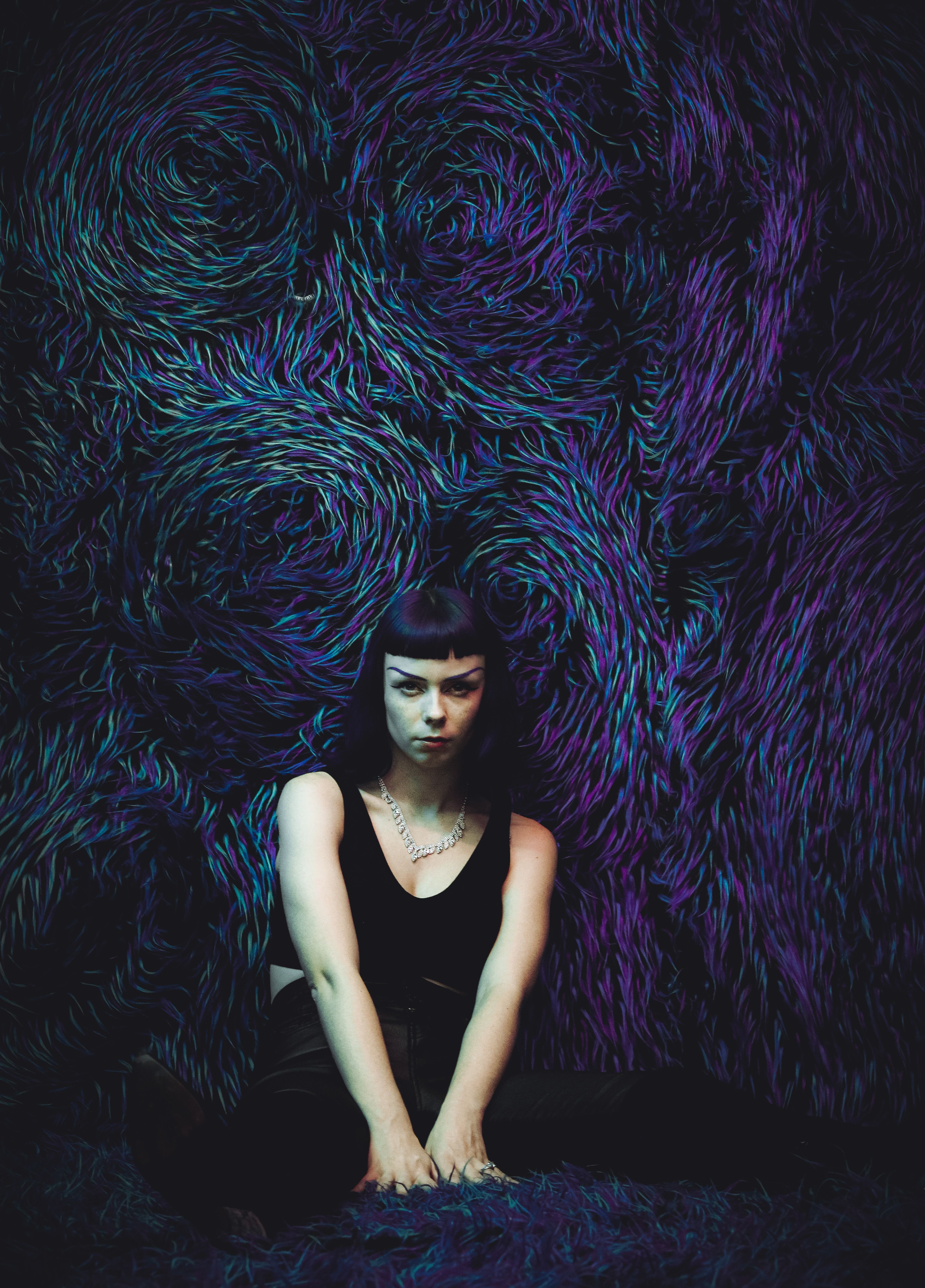 Portrait of a Sitting Woman on the Disturbing Background · Free Stock Photo