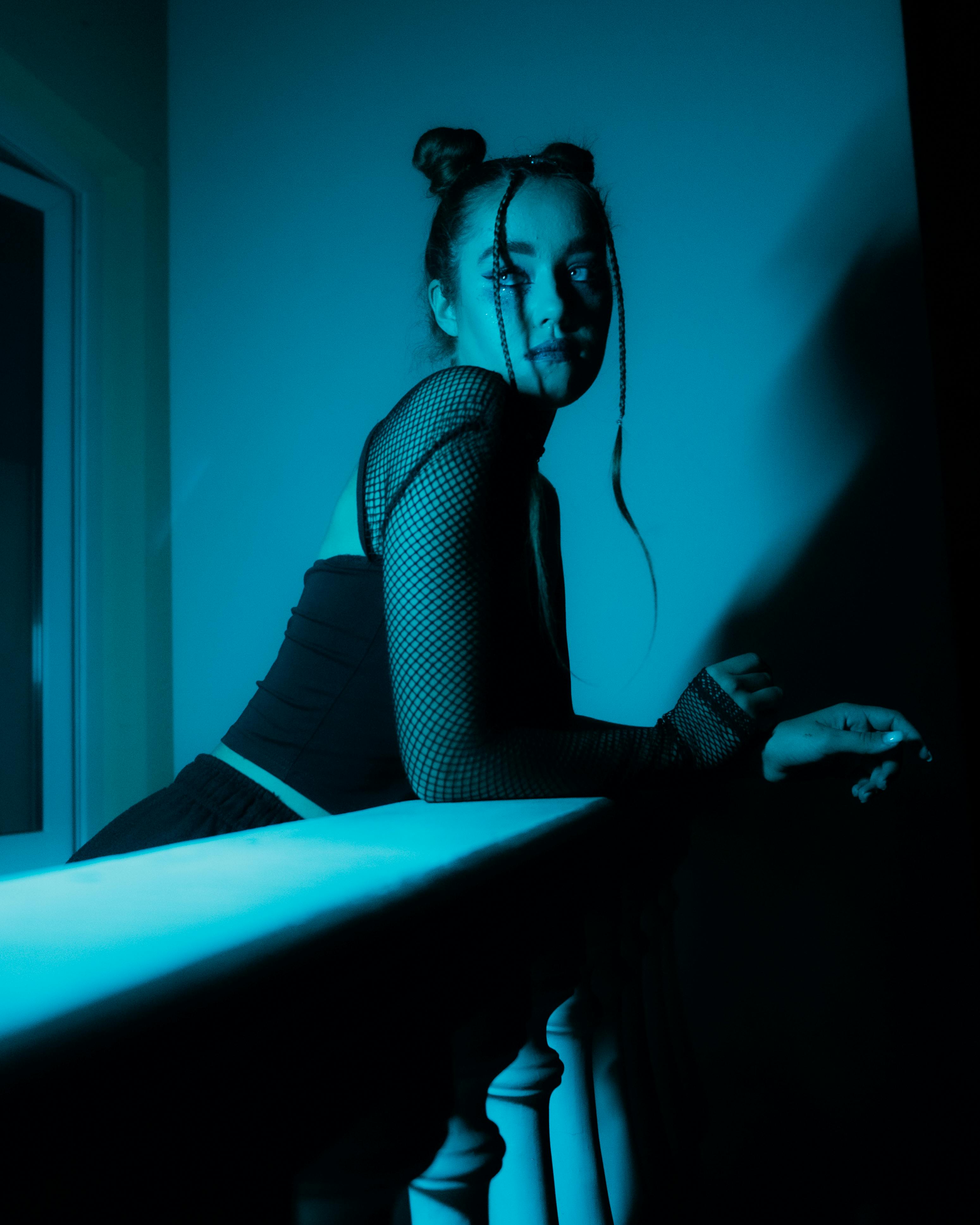 Woman in Mesh Long Sleeves Leaning on a Concrete Railing while Looking ...