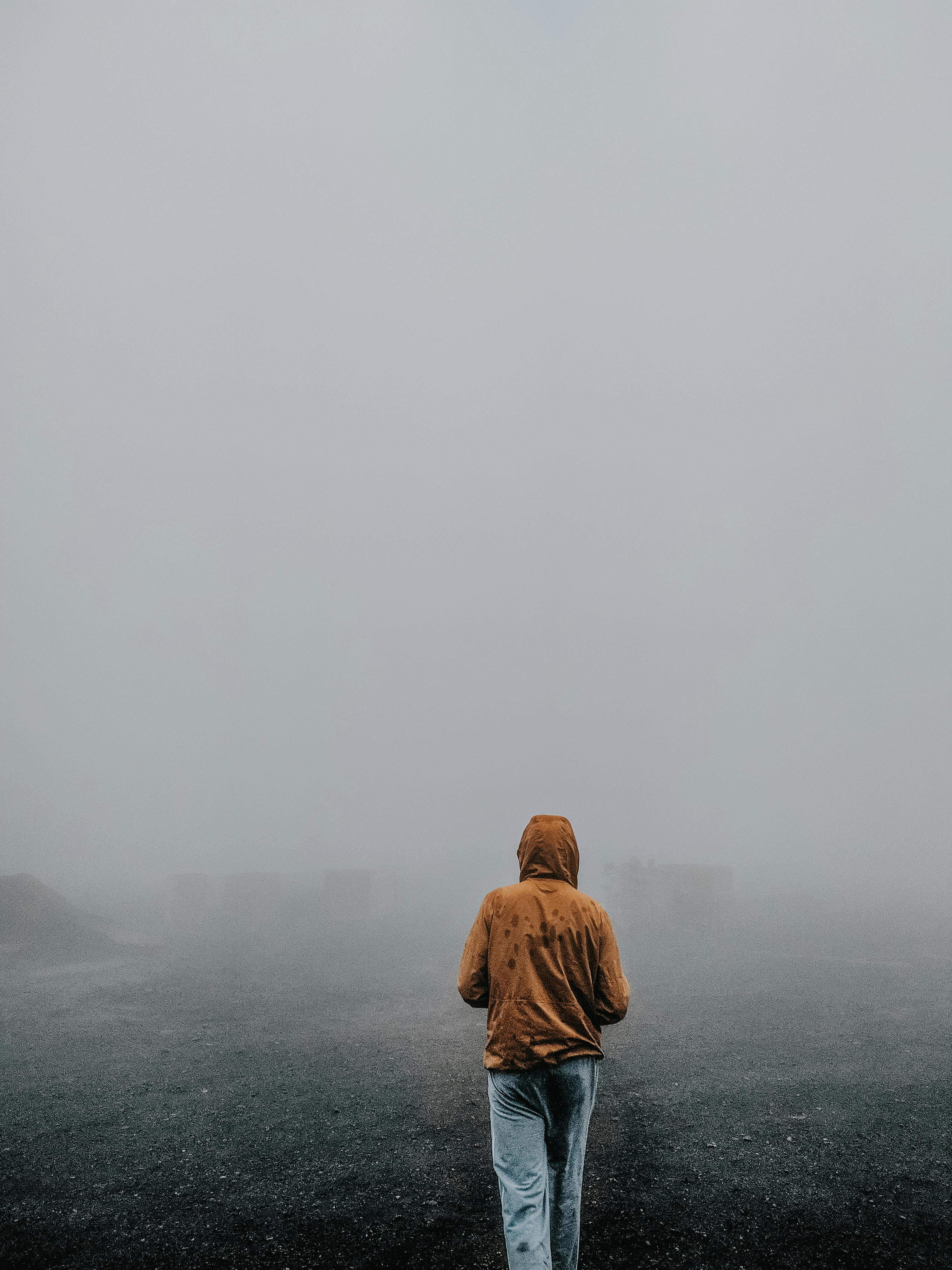 A Man in Brown Jacket Walking Near Fog · Free Stock Photo