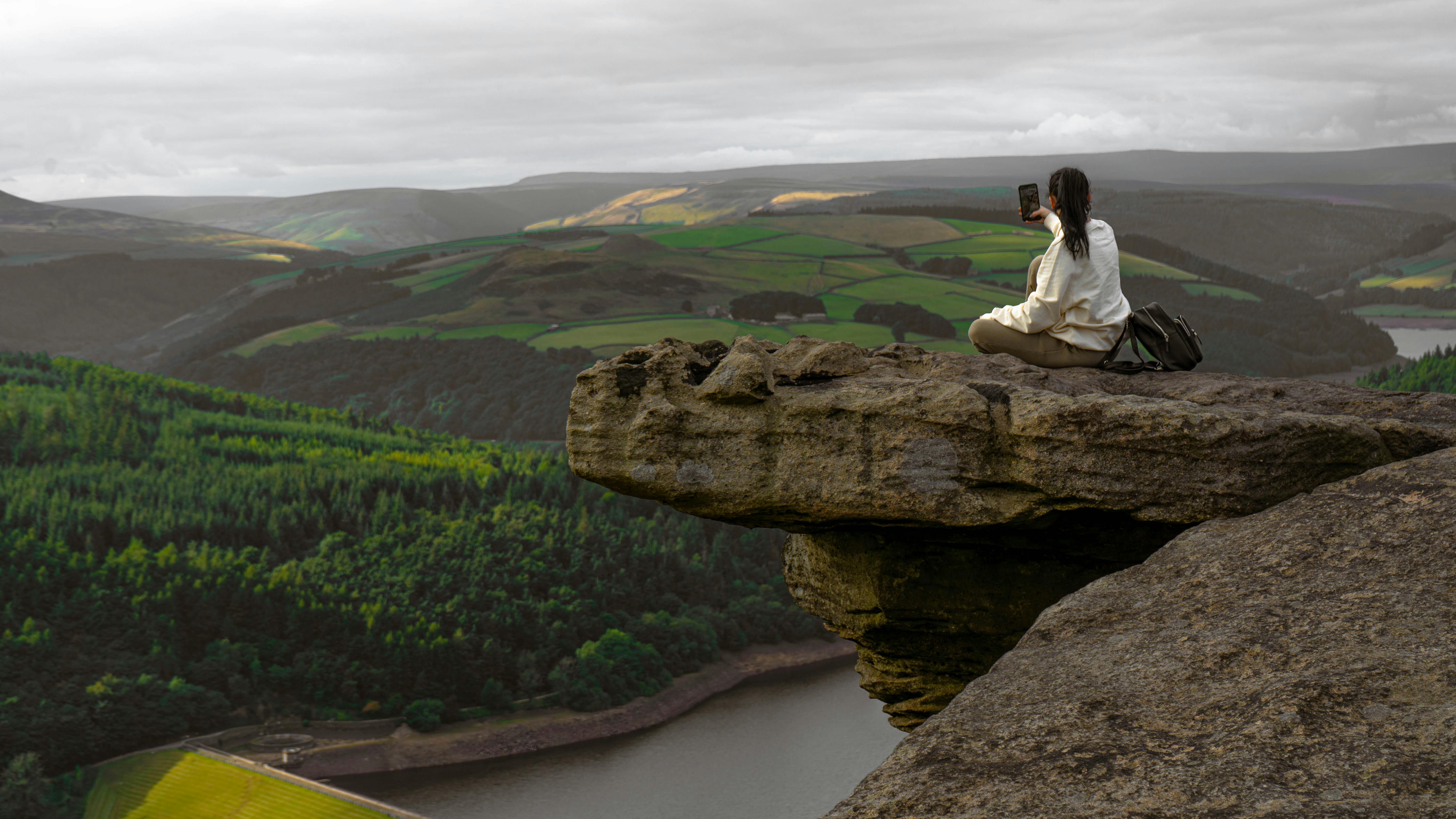 Woman Sitting on Rock on Mountain Top Taking Photo · Free Stock Photo