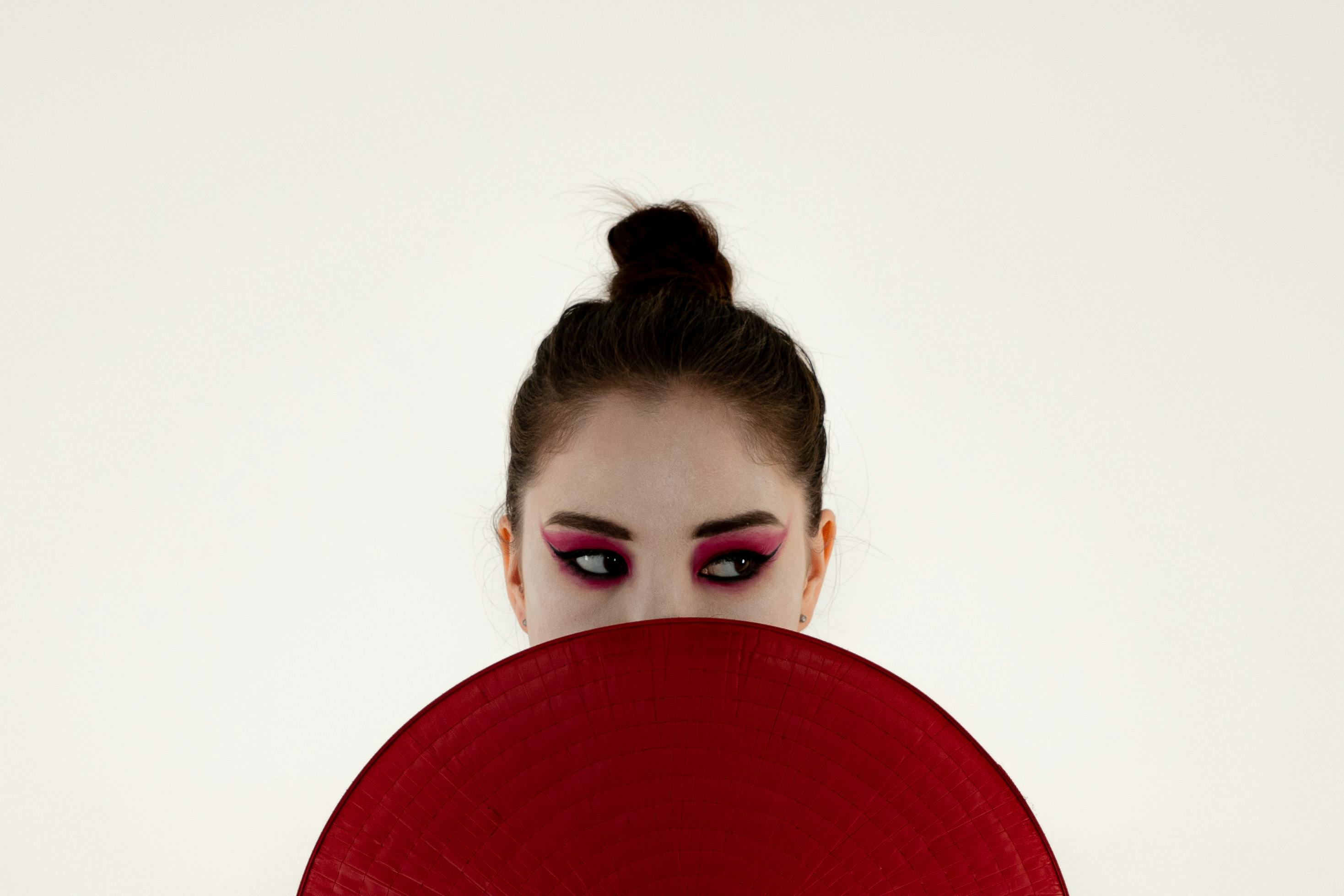 A Woman Covering Her Face with a Hand Fan · Free Stock Photo