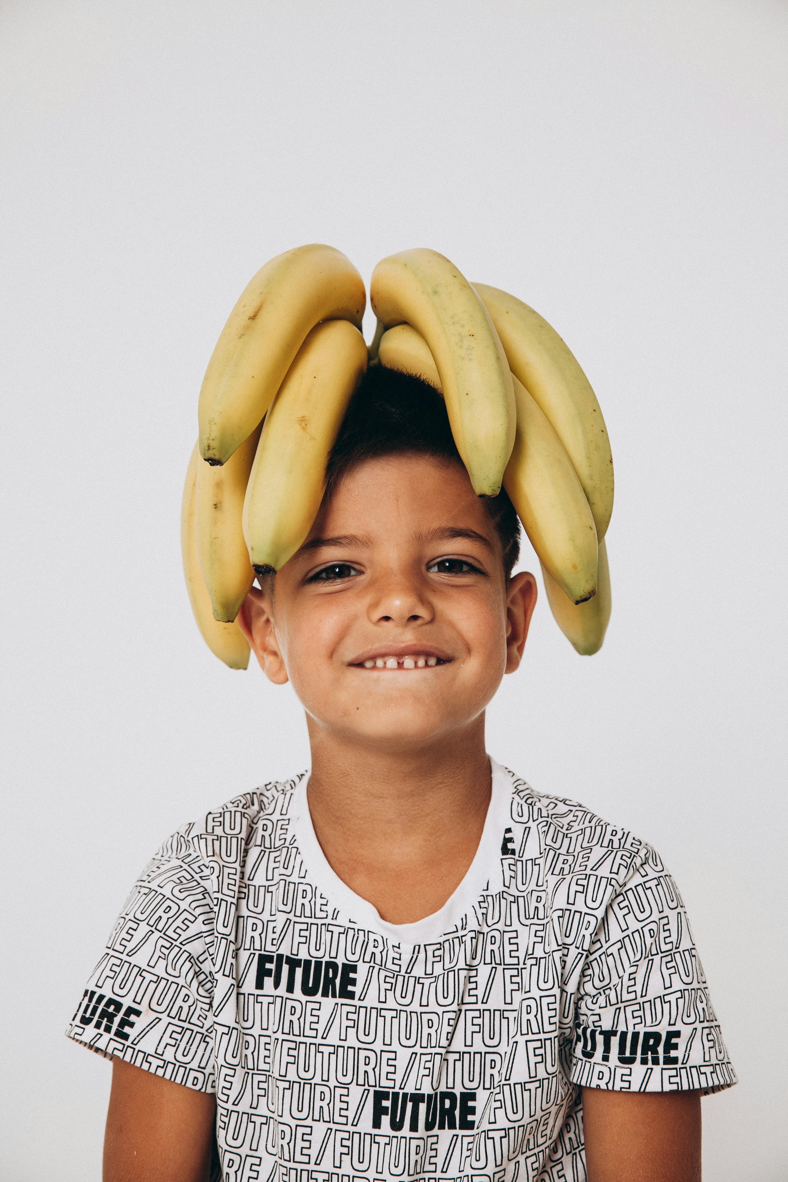 A Young Boy with Banana Fruits on his Head · Free Stock Photo