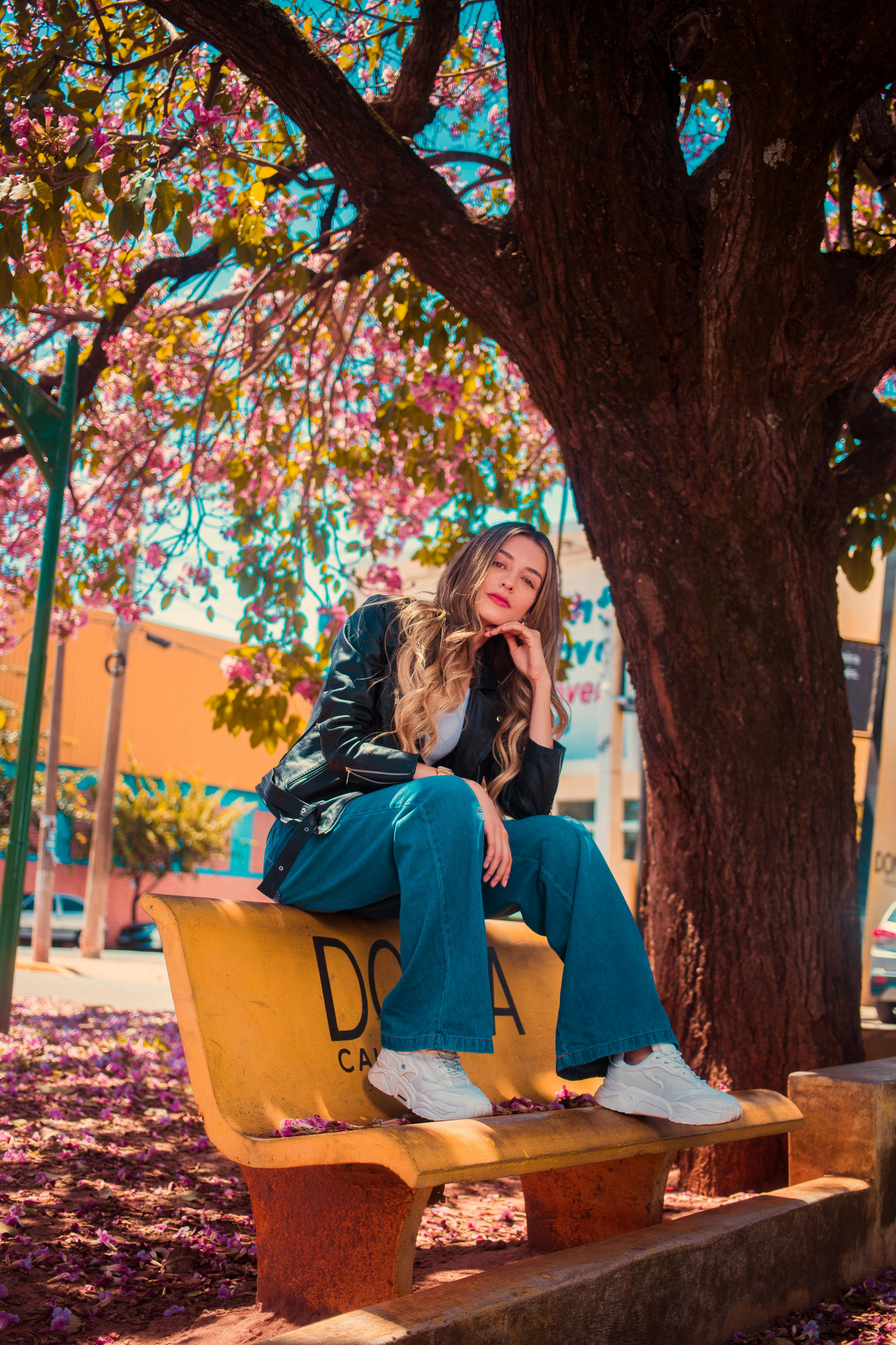 Woman in Black Jacket and Blue Denim Jeans Sitting on a Bench · Free ...