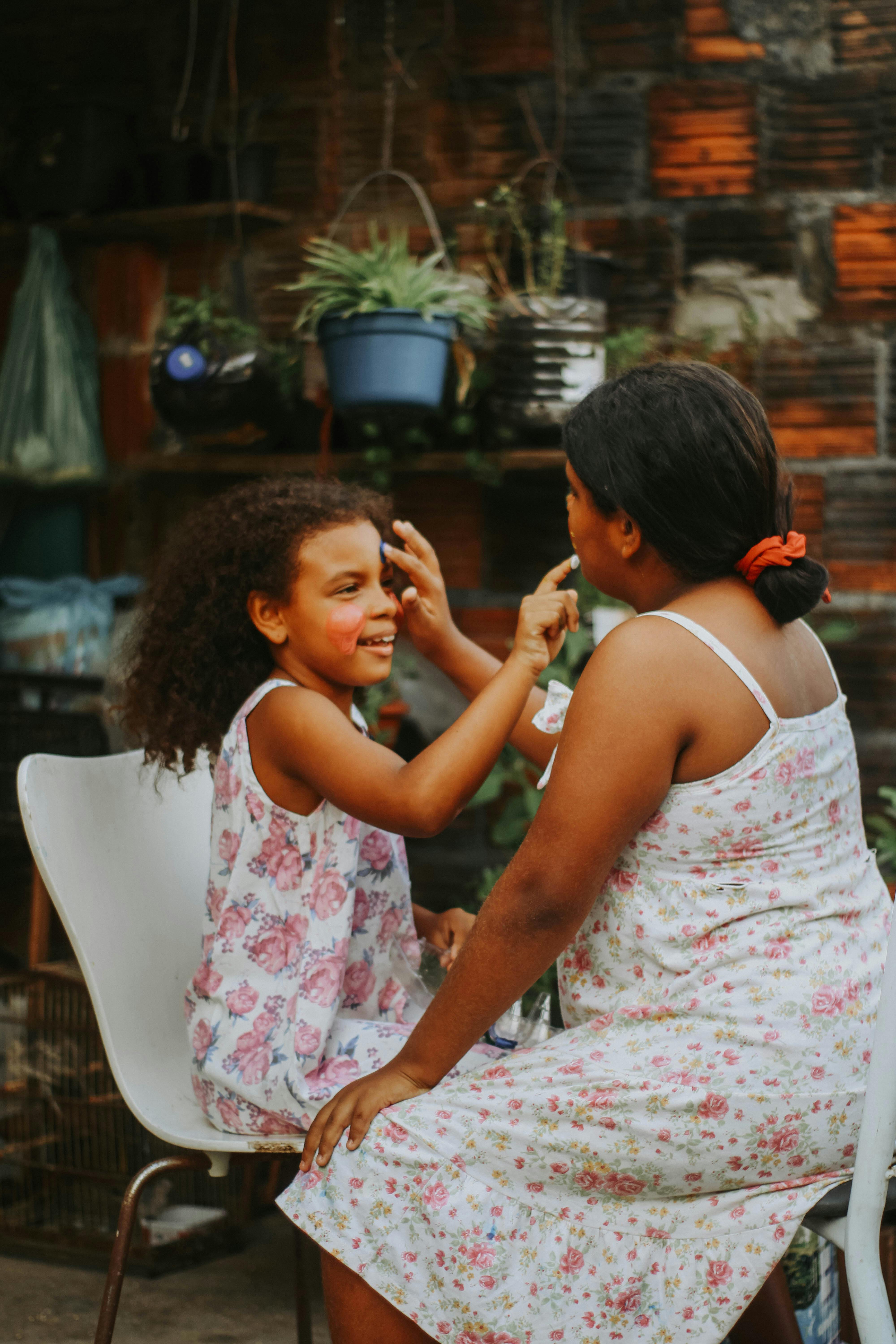 Woman and Girl Putting Face Paint on Each Other · Free Stock Photo