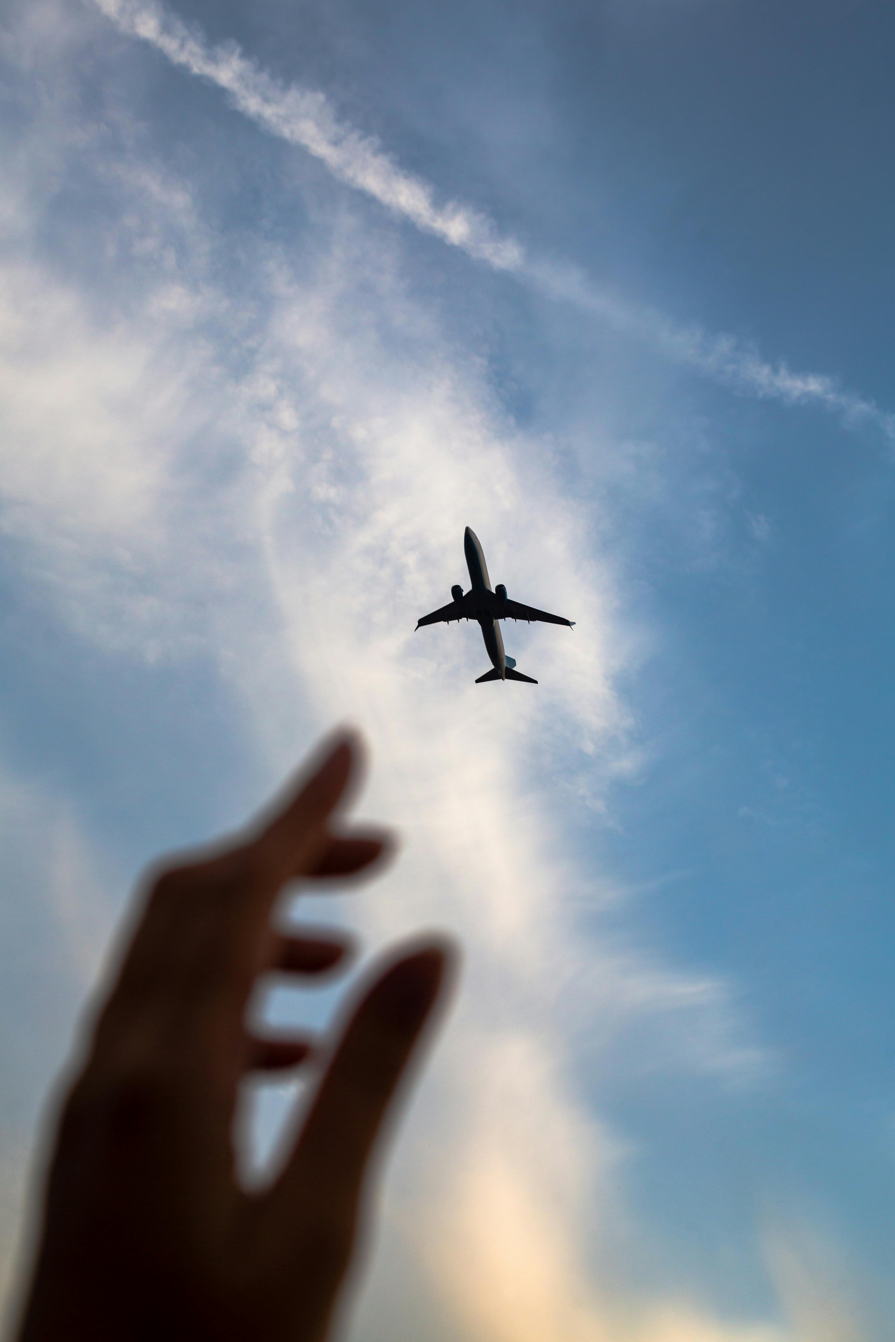 Hand Reaching towards Airplane · Free Stock Photo