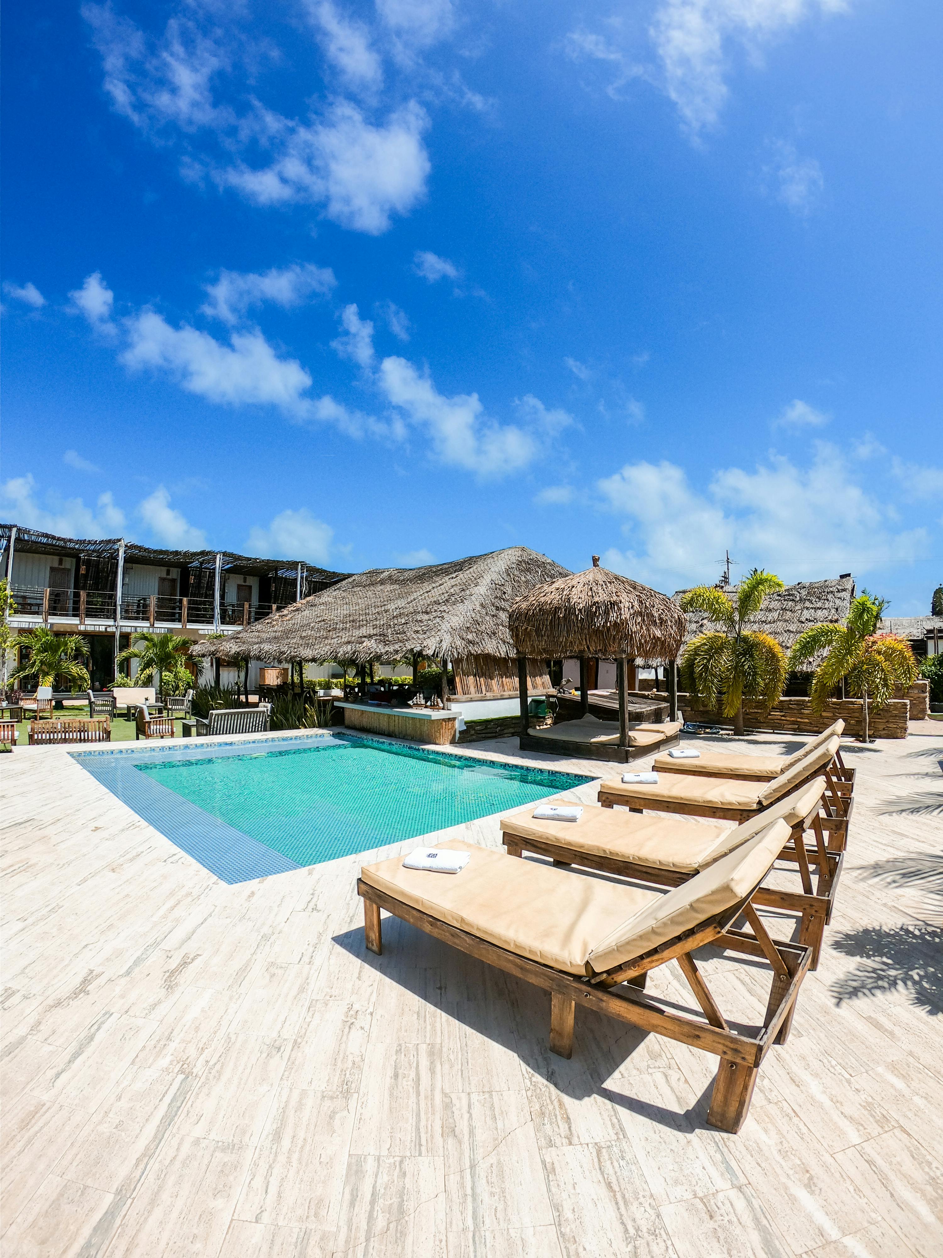 Sunbeds by Pool under Blue Sky · Free Stock Photo