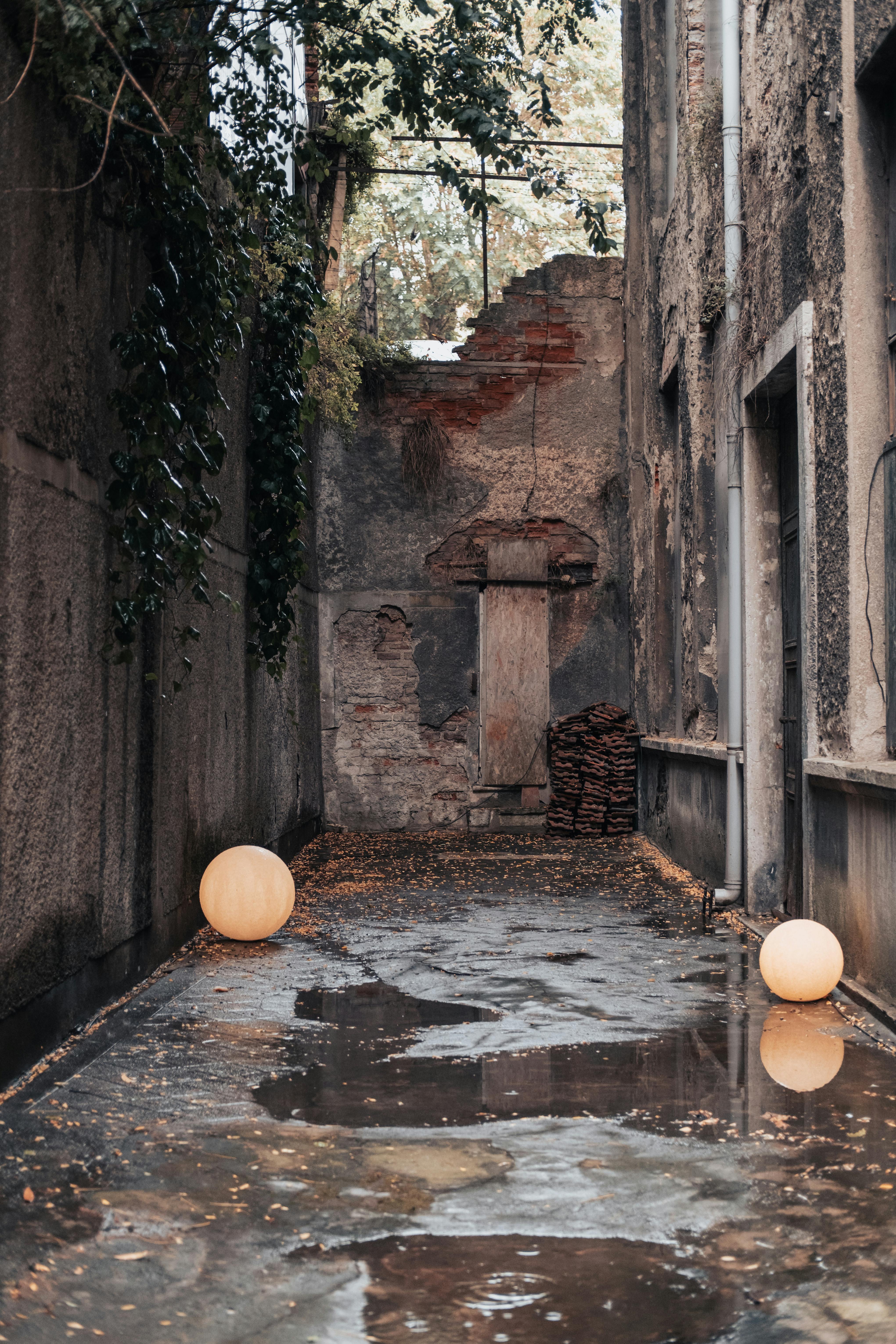 Two Spheres Lying in an Empty Alley · Free Stock Photo